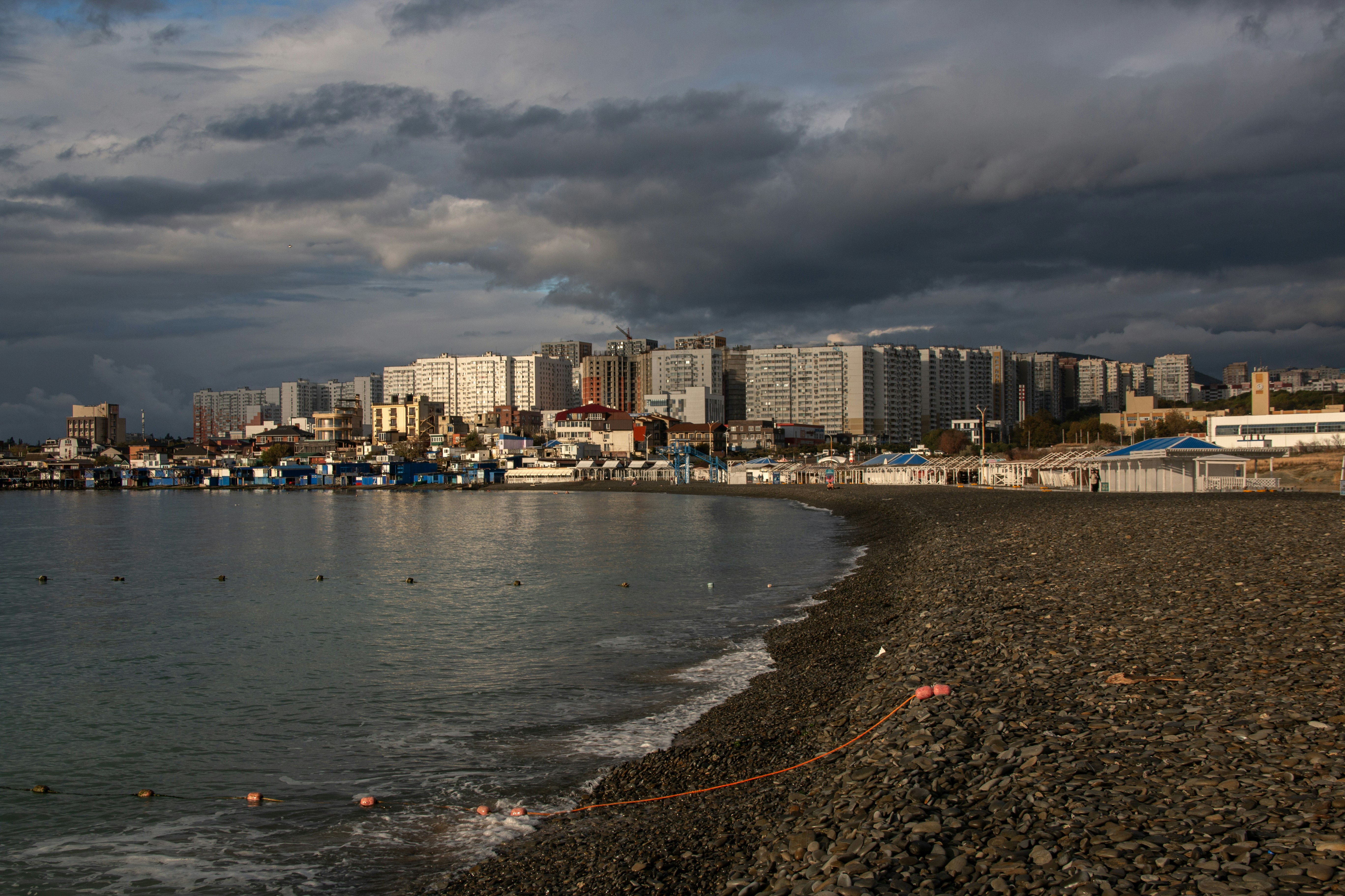 Coastal city skyline with apartment buildings and harbor.