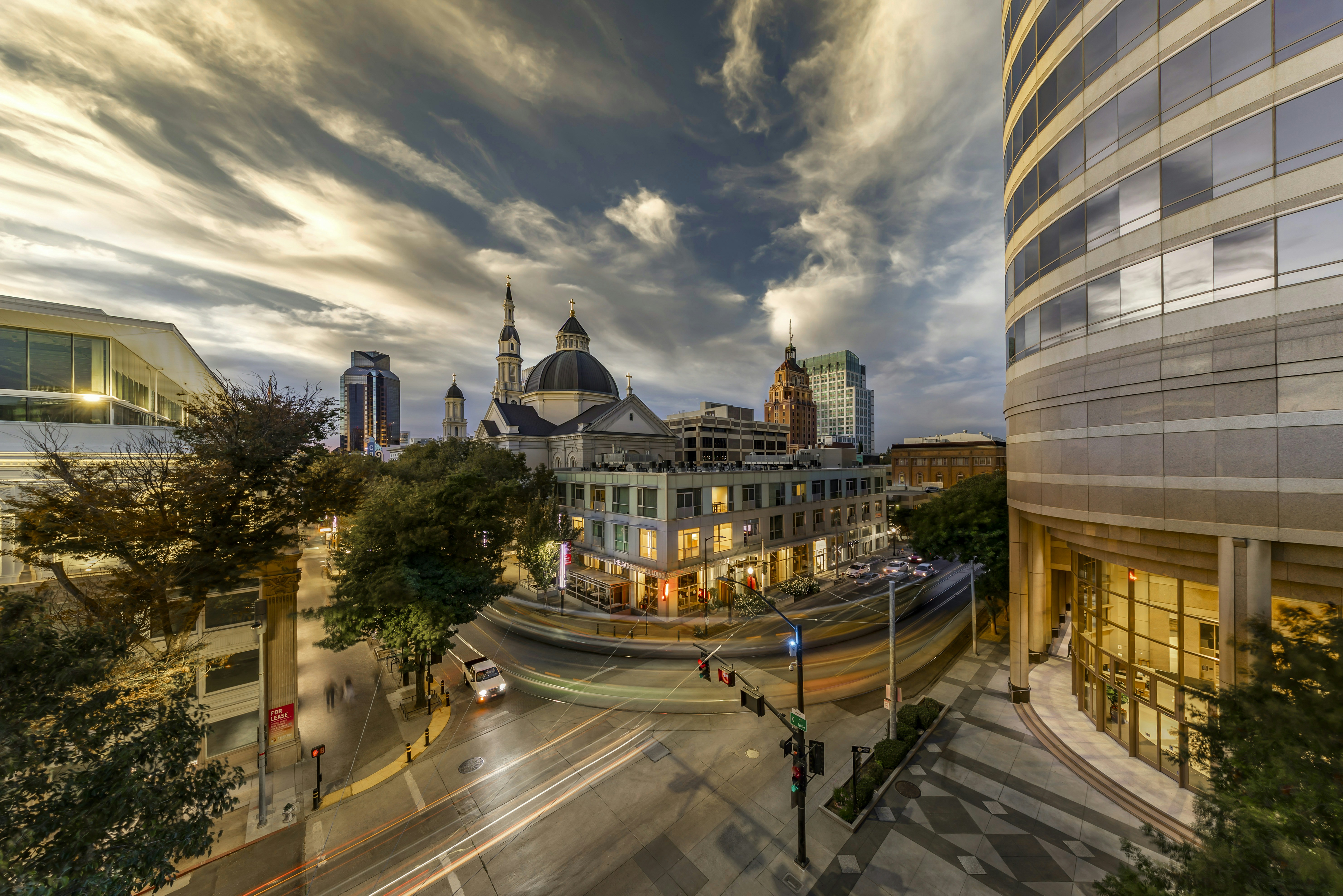Cityscape with domed building and modern architecture at sunset.