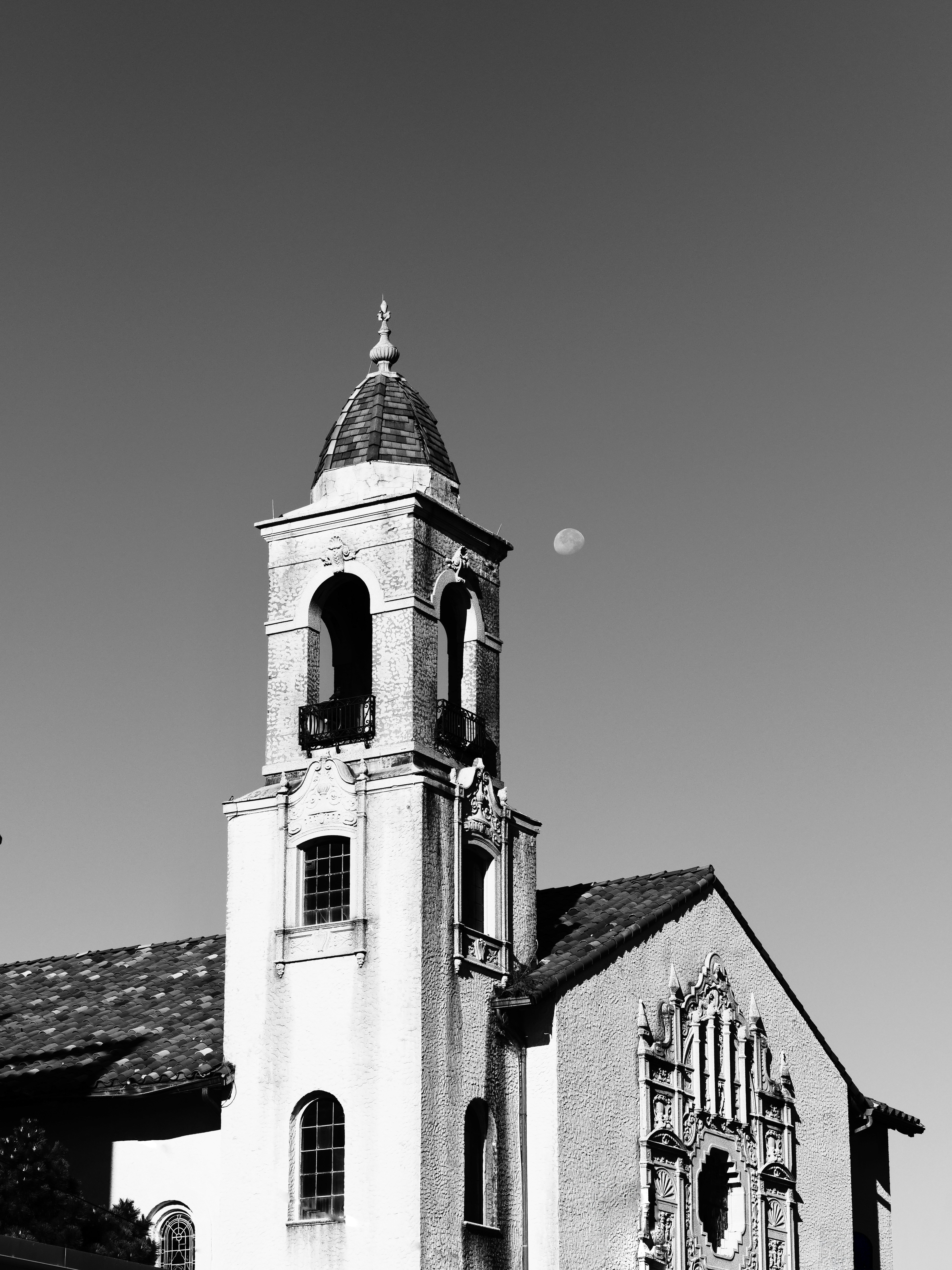 Church with moon | Bell tower of an old building against a clear sky.
