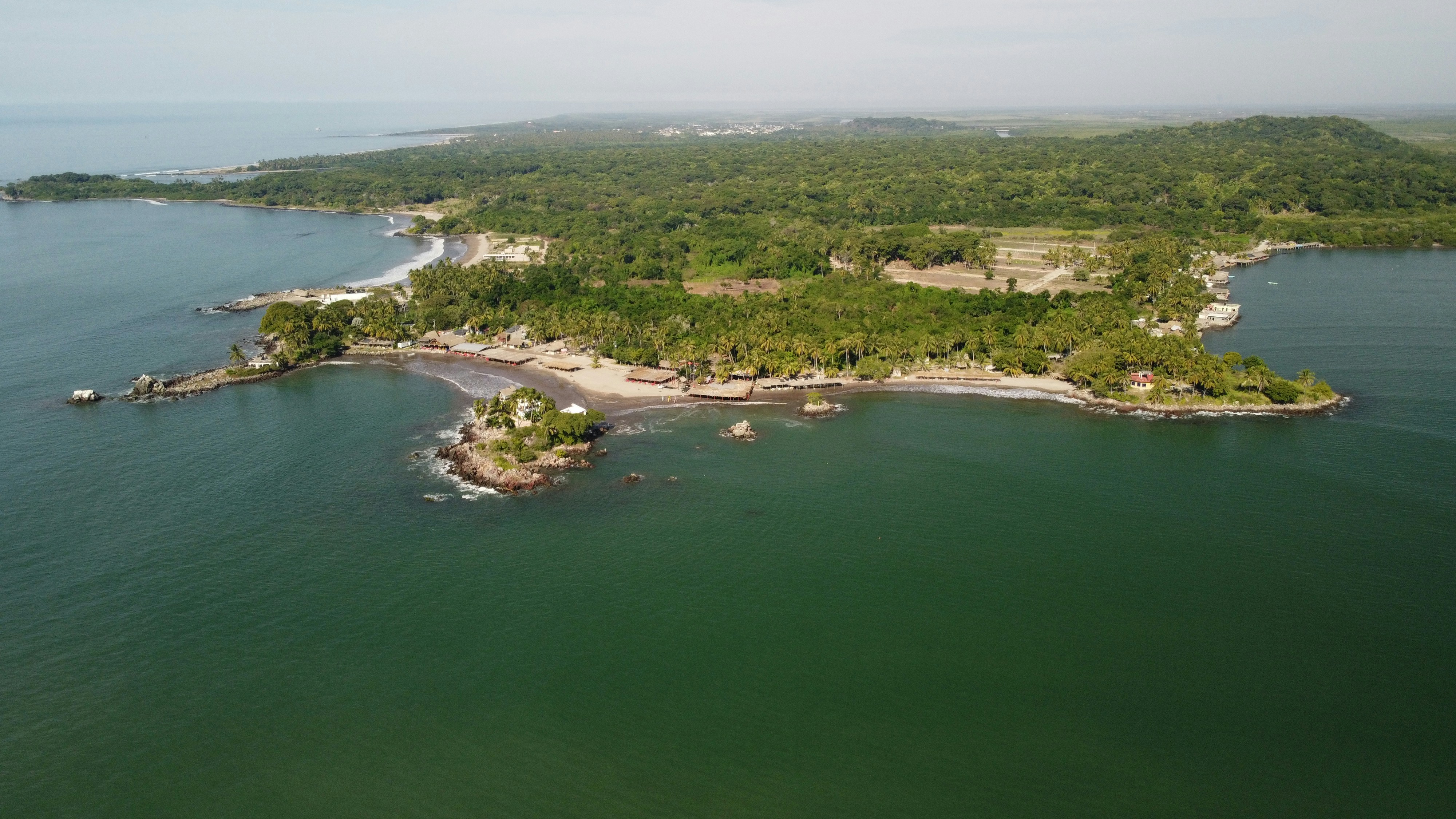 Exuberante isla verde con costa rocosa y mar en calma foto – Imagen de ...