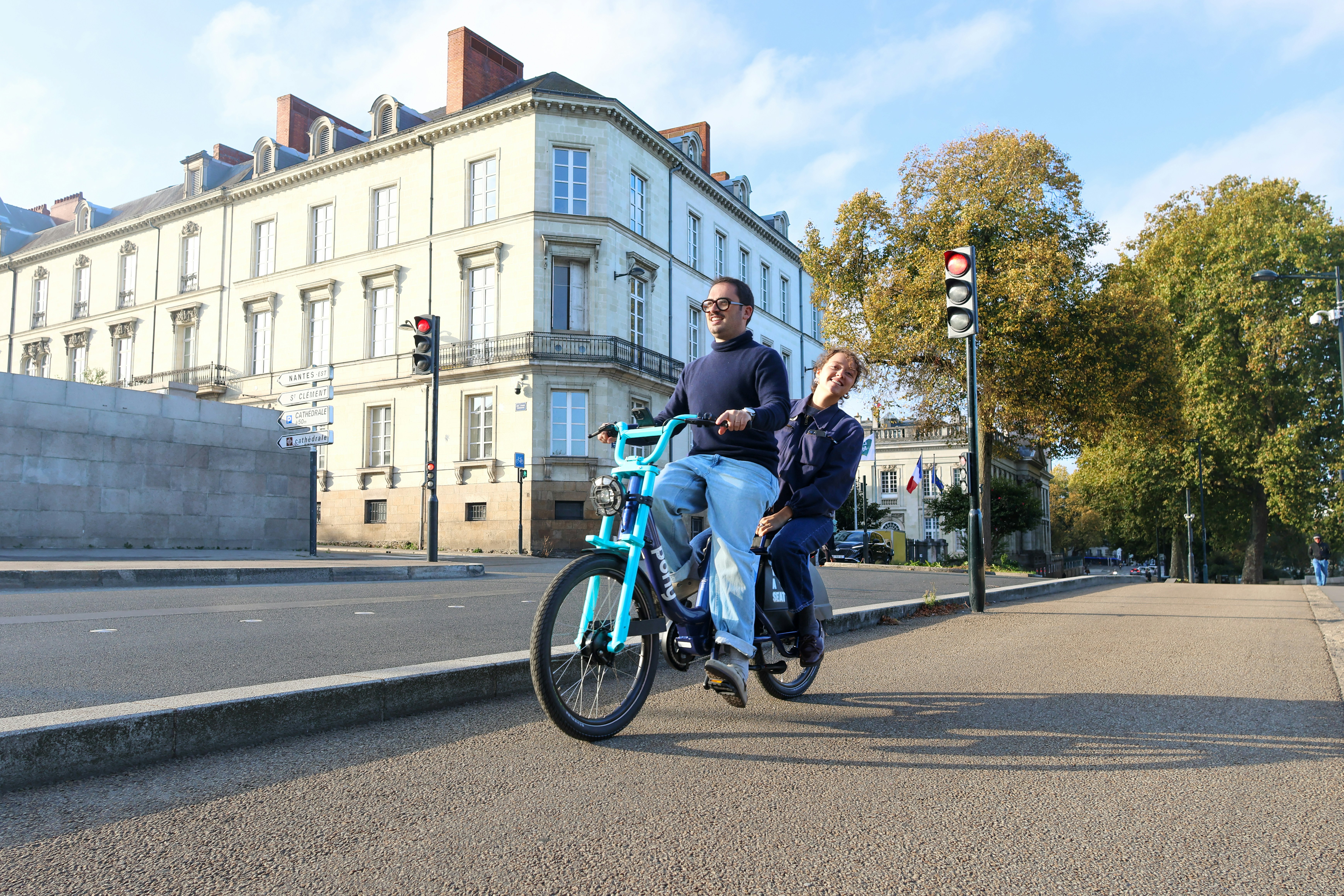 Couple riding a tandem bicycle on a sunny day.