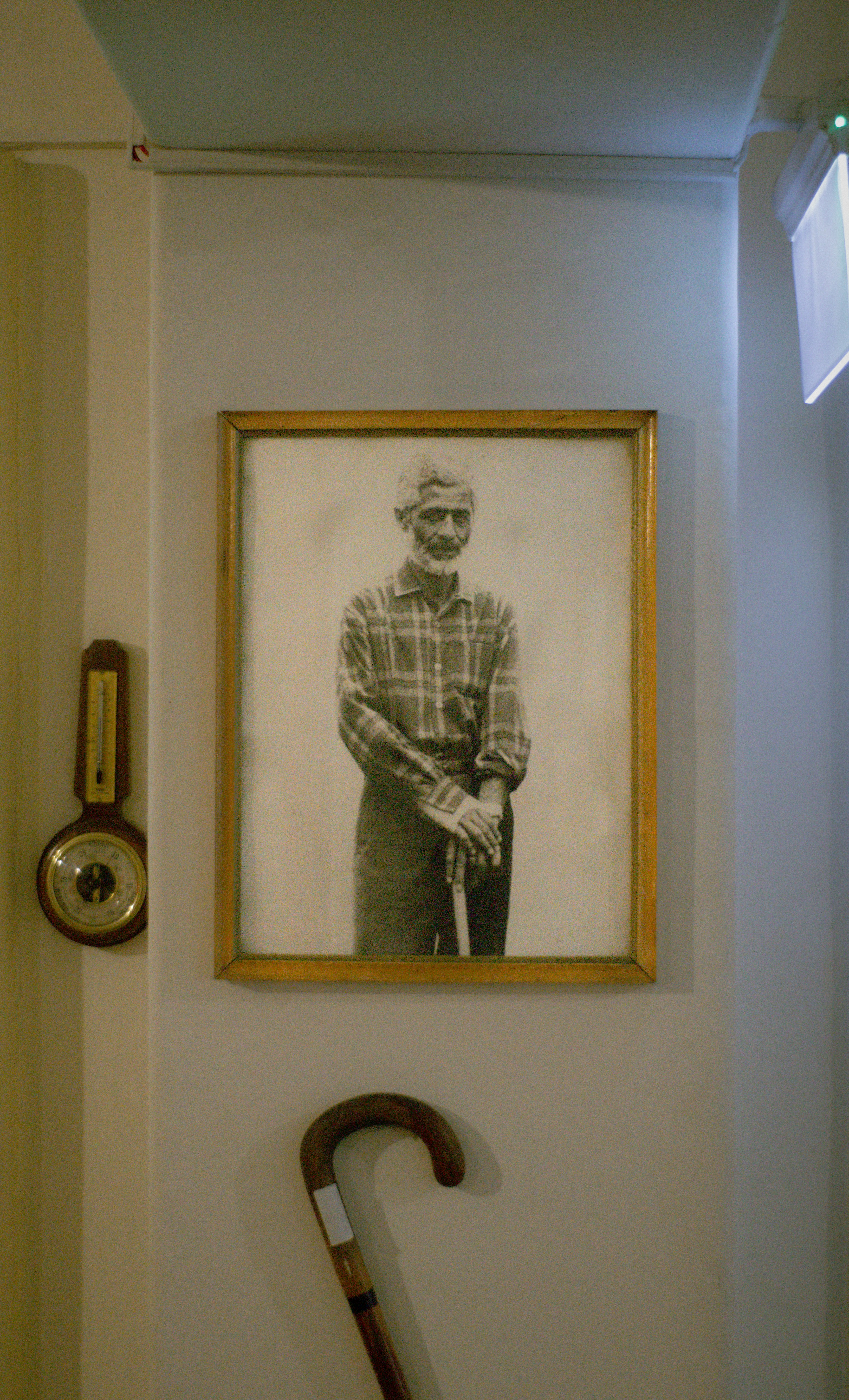 Jalal Al-e-Ahmad, a presence that still resonates. | Framed portrait of a man with a cane below.
