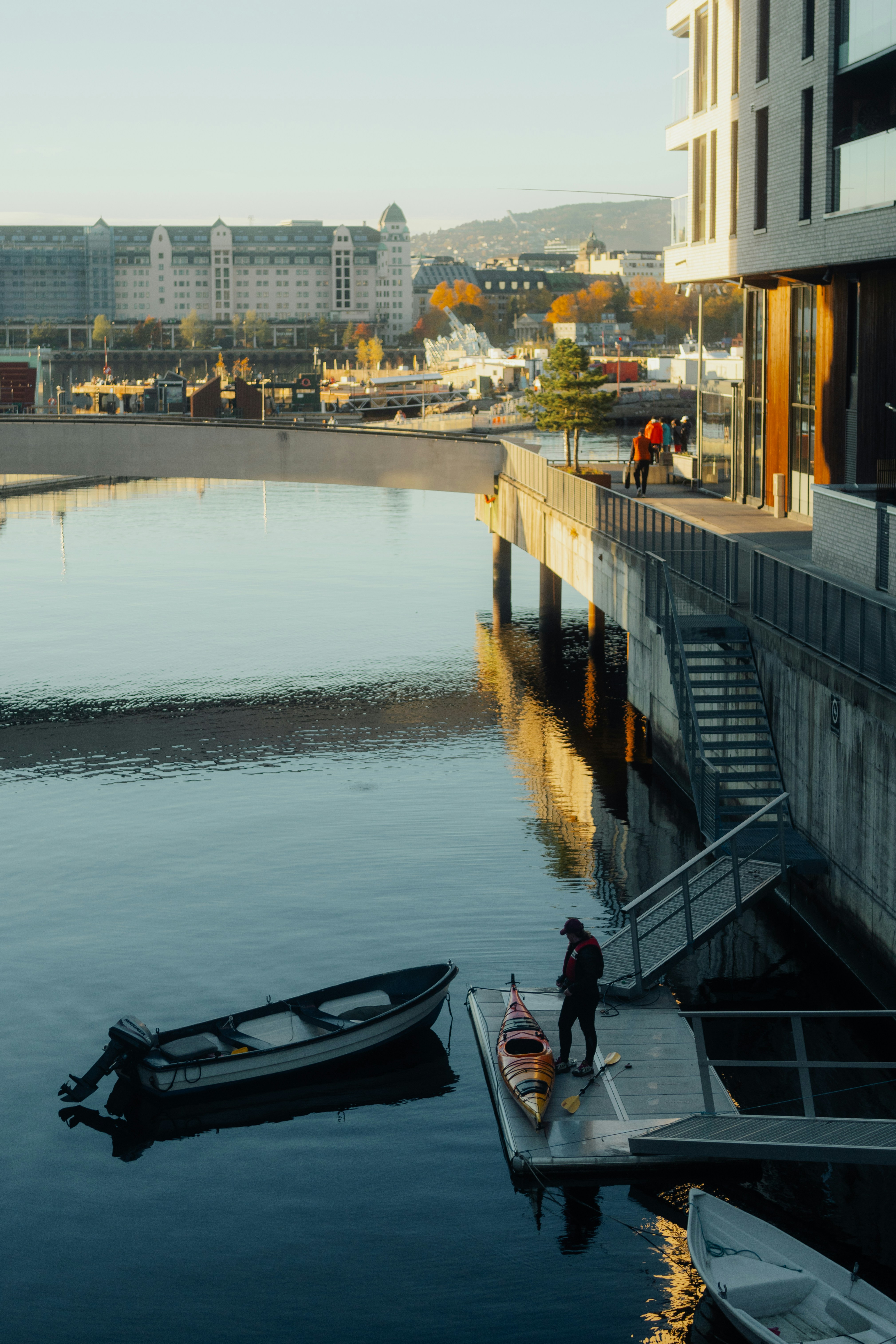 Sunlit Riverside Promenade with Reflections and Modern Waterfront