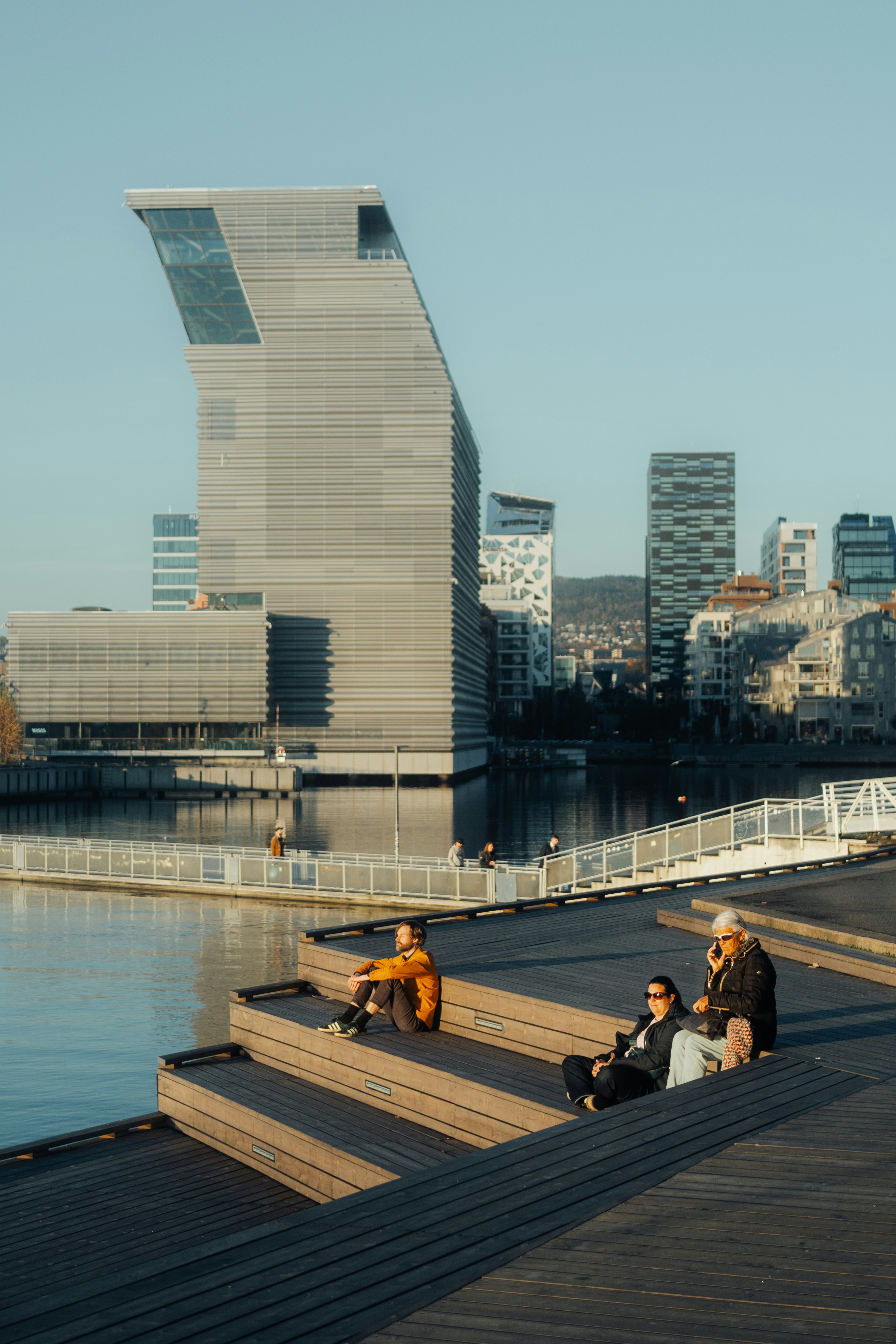 Concrete steps to calm: sunlit harbor reflections near a futuristic tower