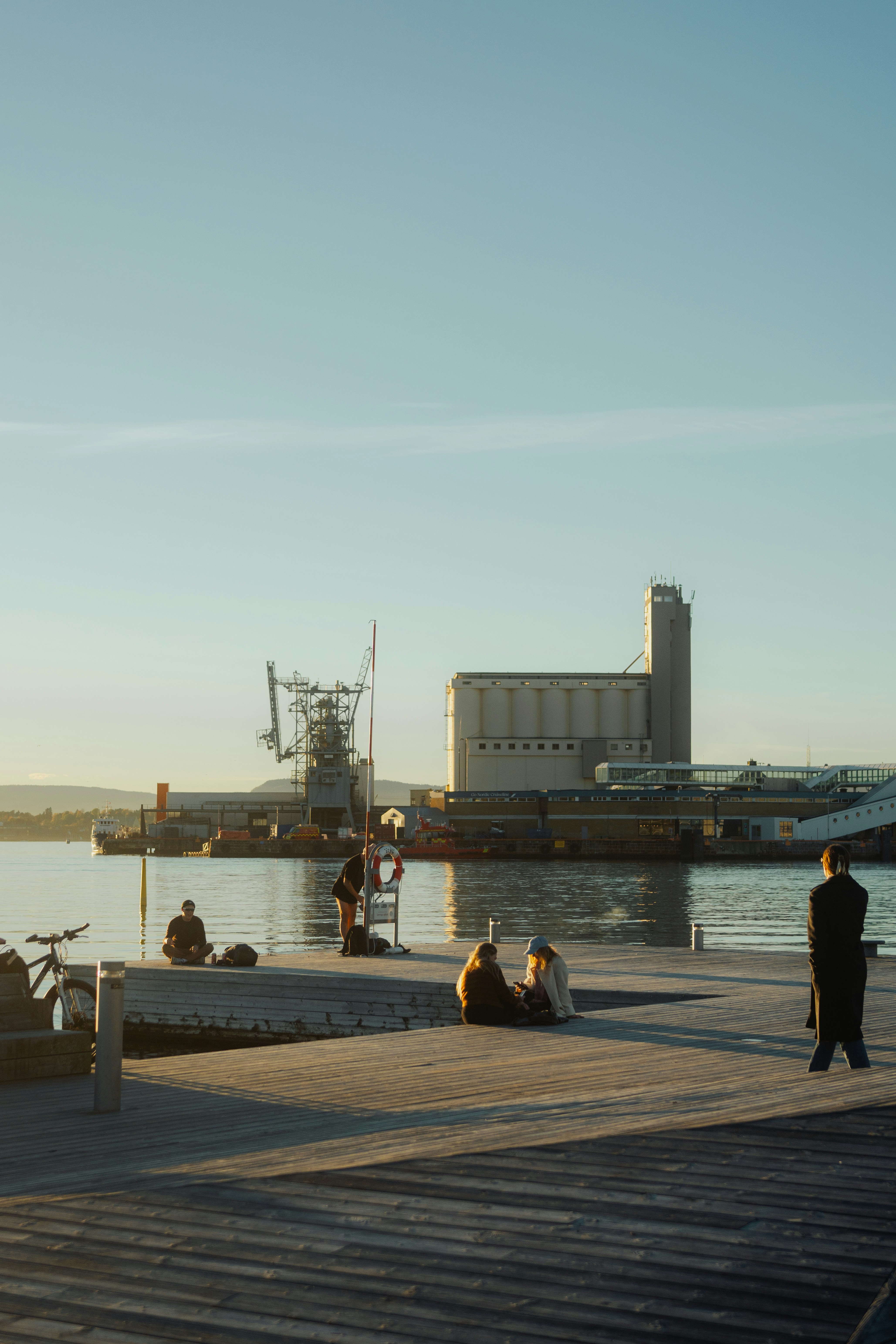 Sunset on the Pier: Quiet Moments Amid Harbor Cranes