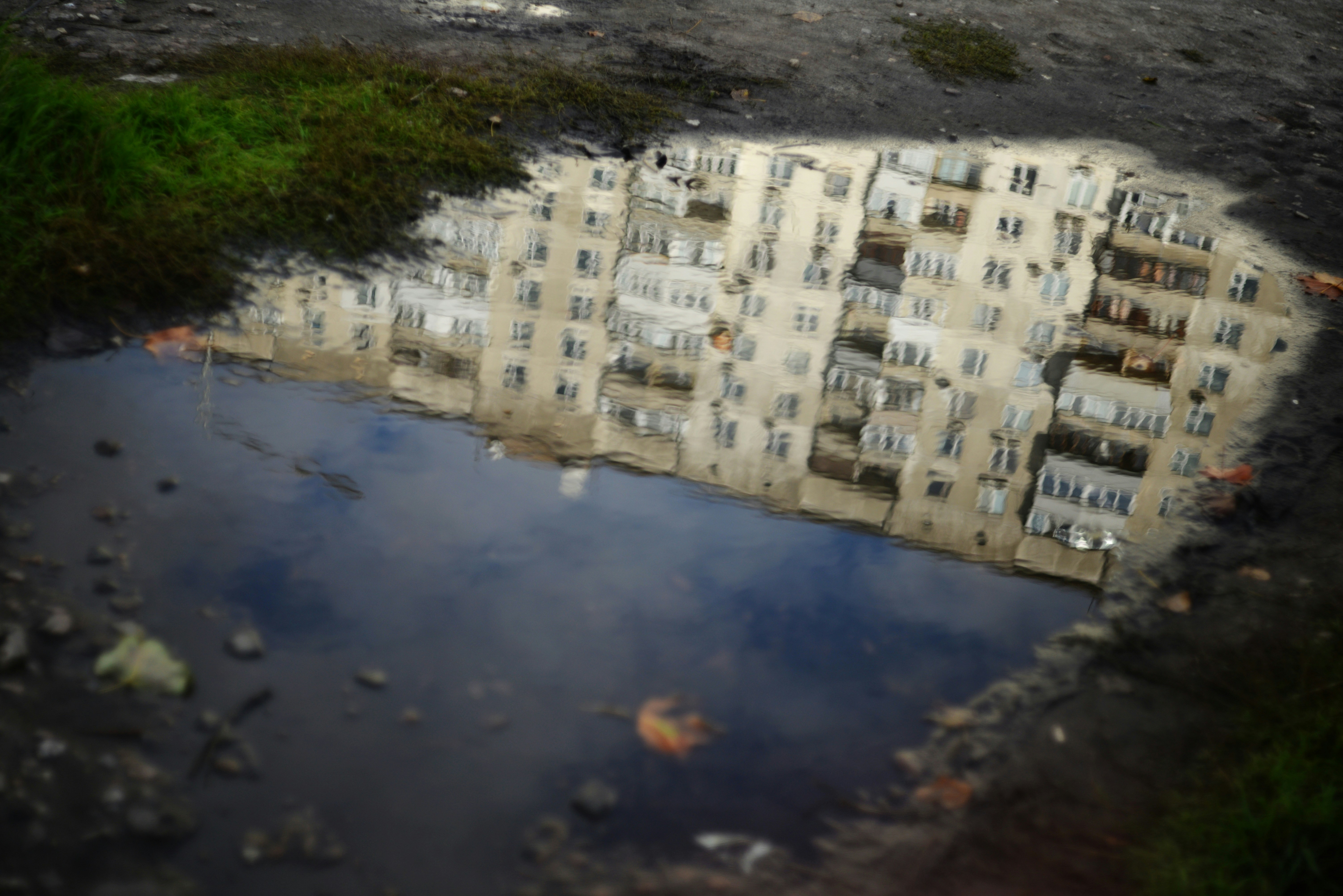 Apartment building reflected in a puddle