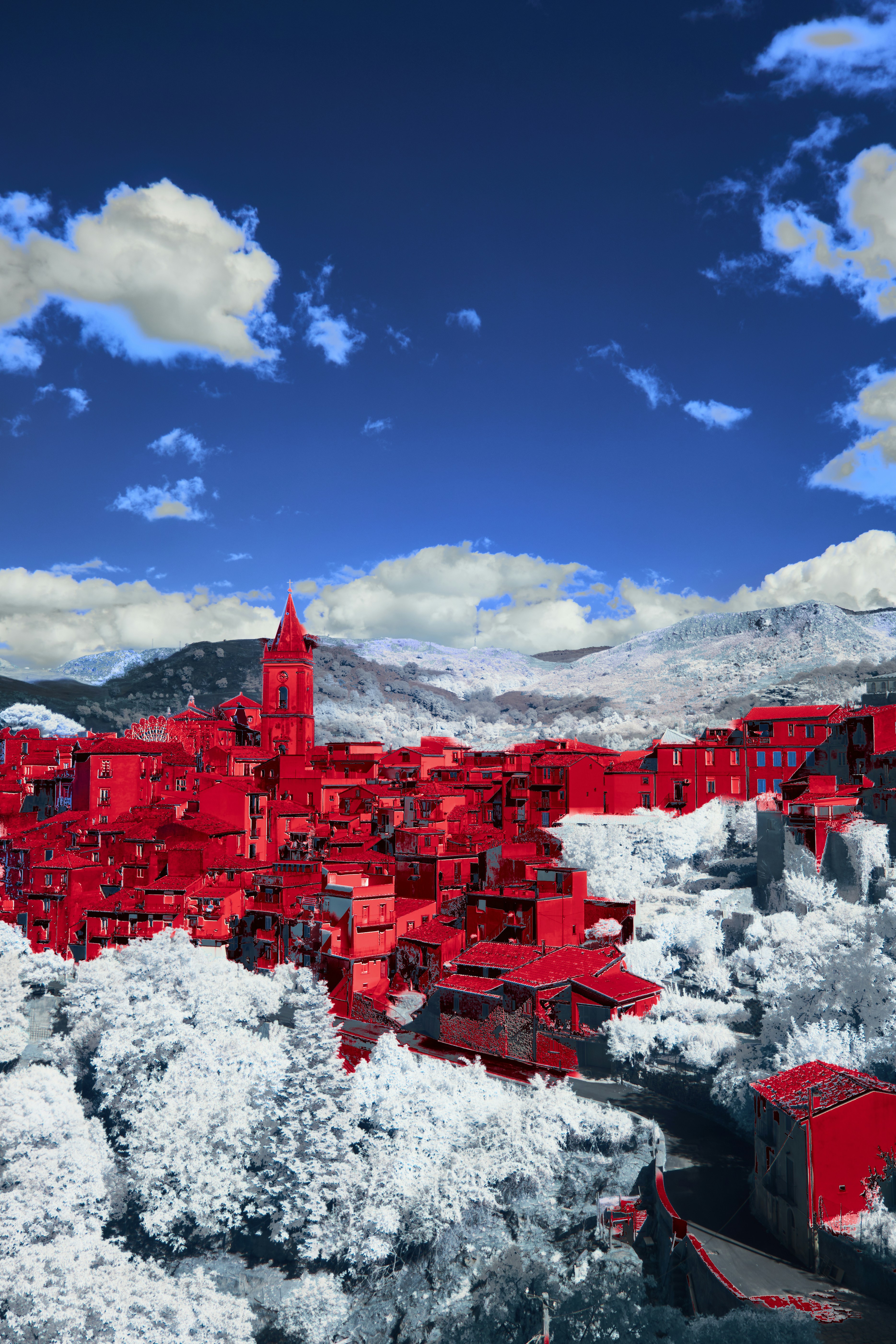 Vibrant red village under a bright blue sky.