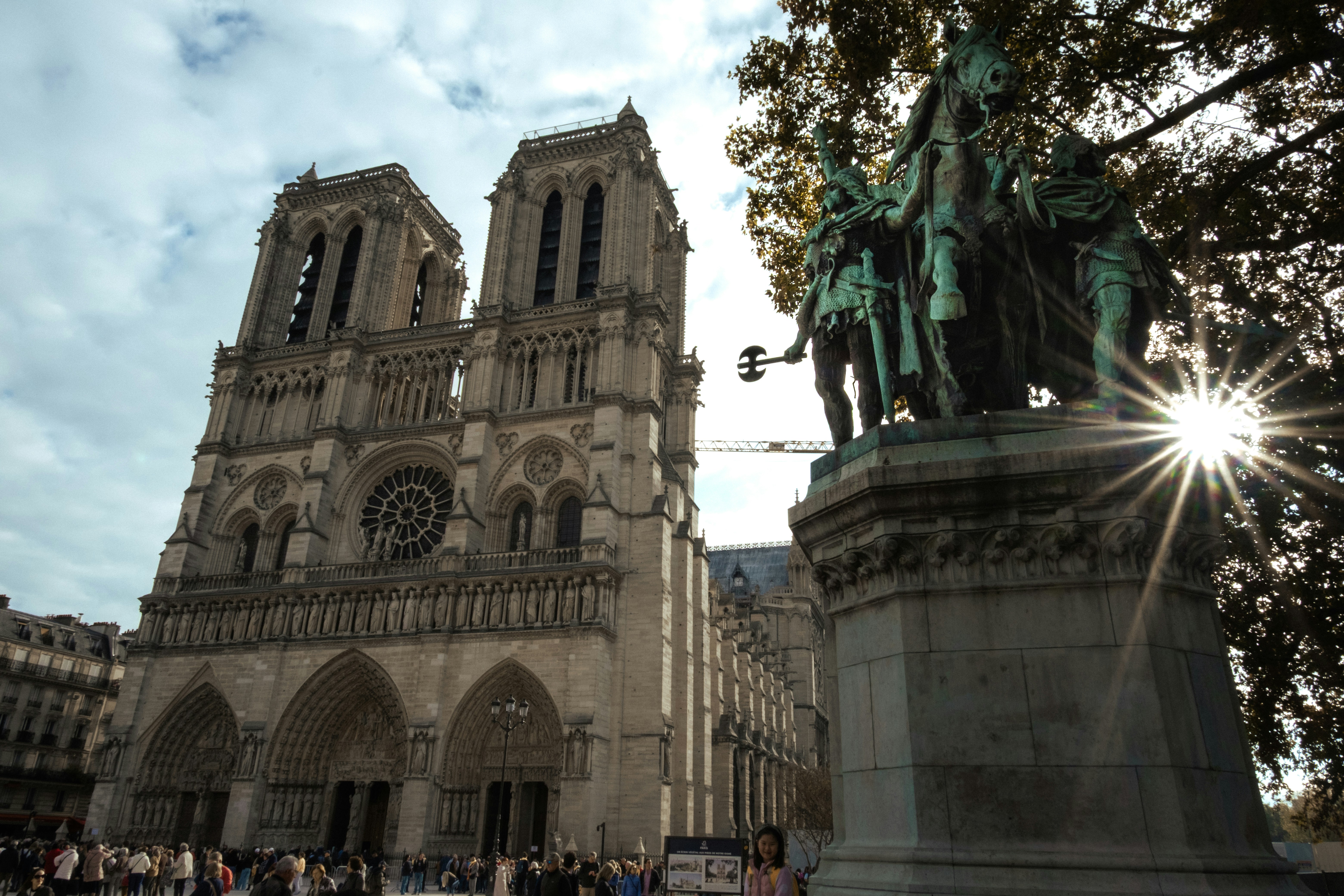 Notre dame cathedral with equestrian statue and sunburst