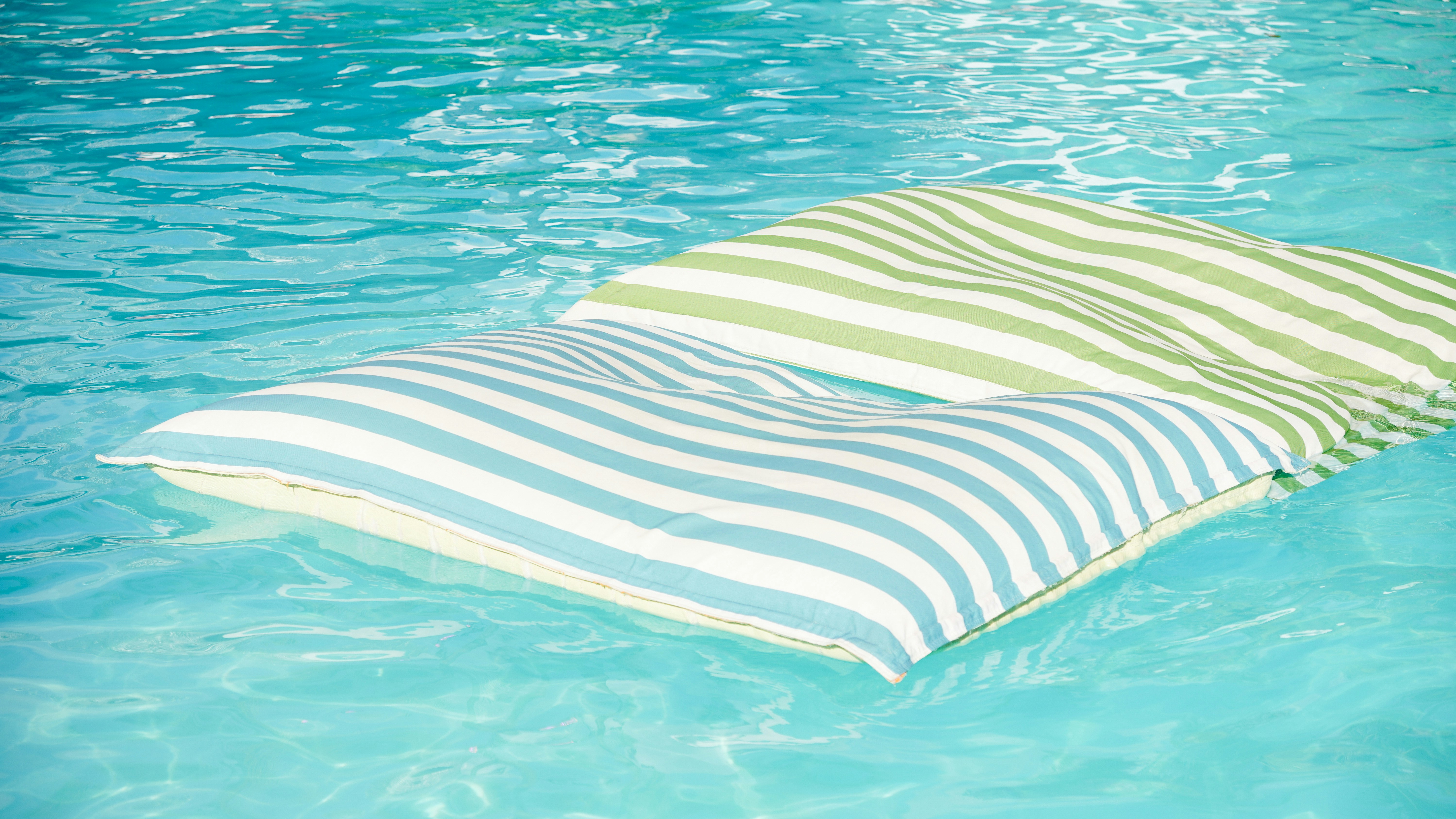 Stripe Drift: Cushions Idle on a Sunlit Pool