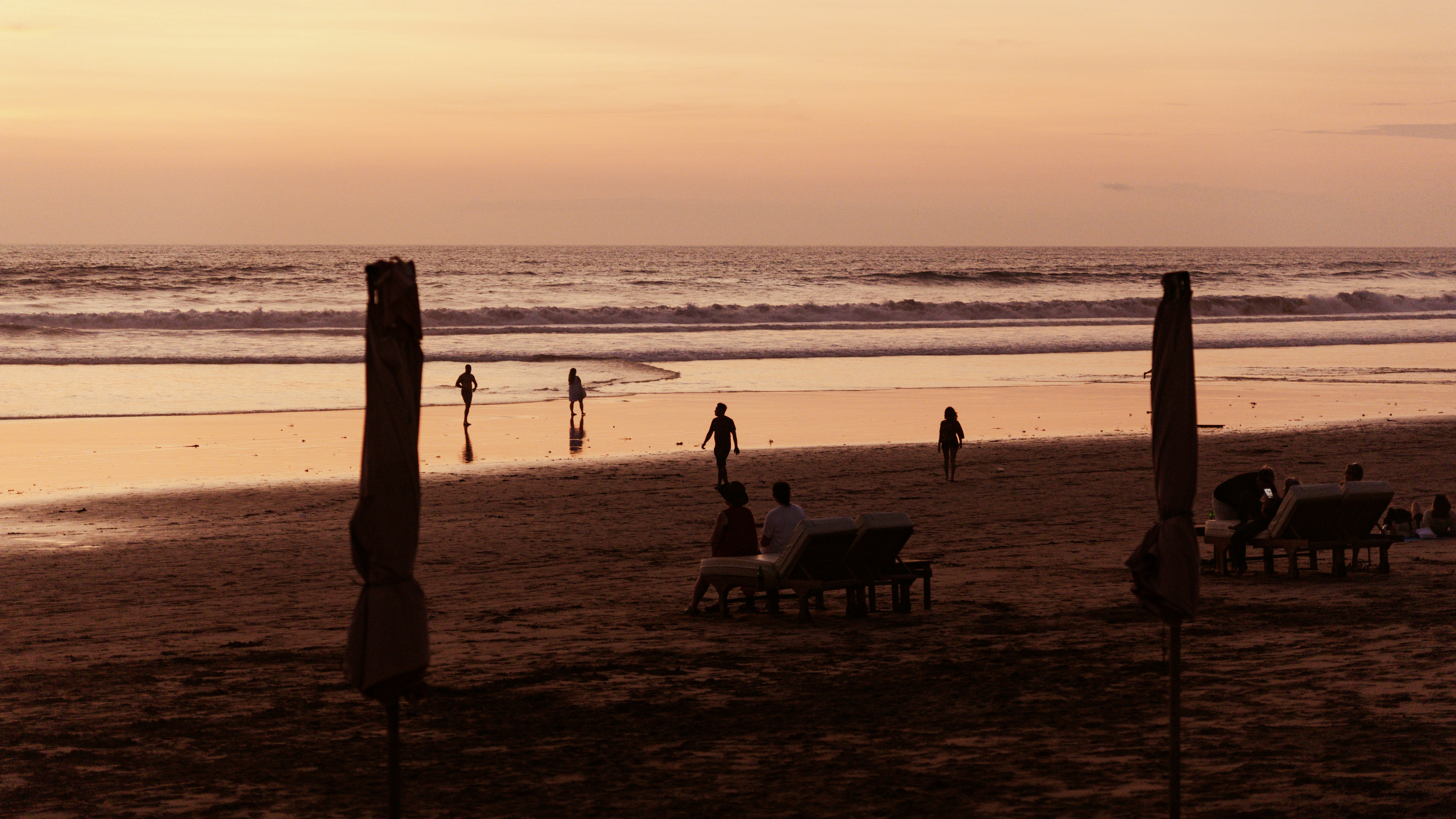 People relaxing on a beach at sunset