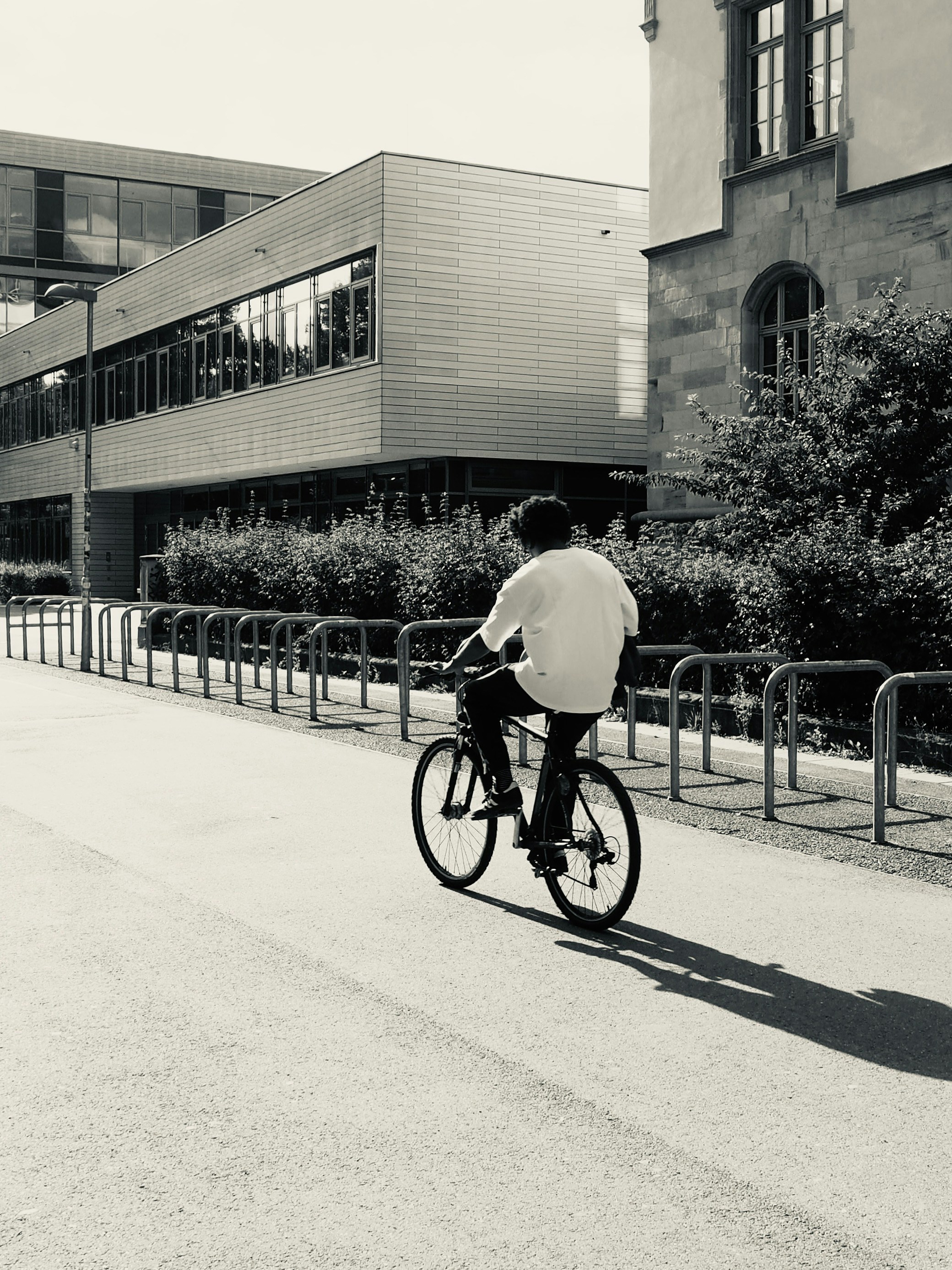 OLYMPUS DIGITAL CAMERA | Person riding a bicycle on a sunny day.