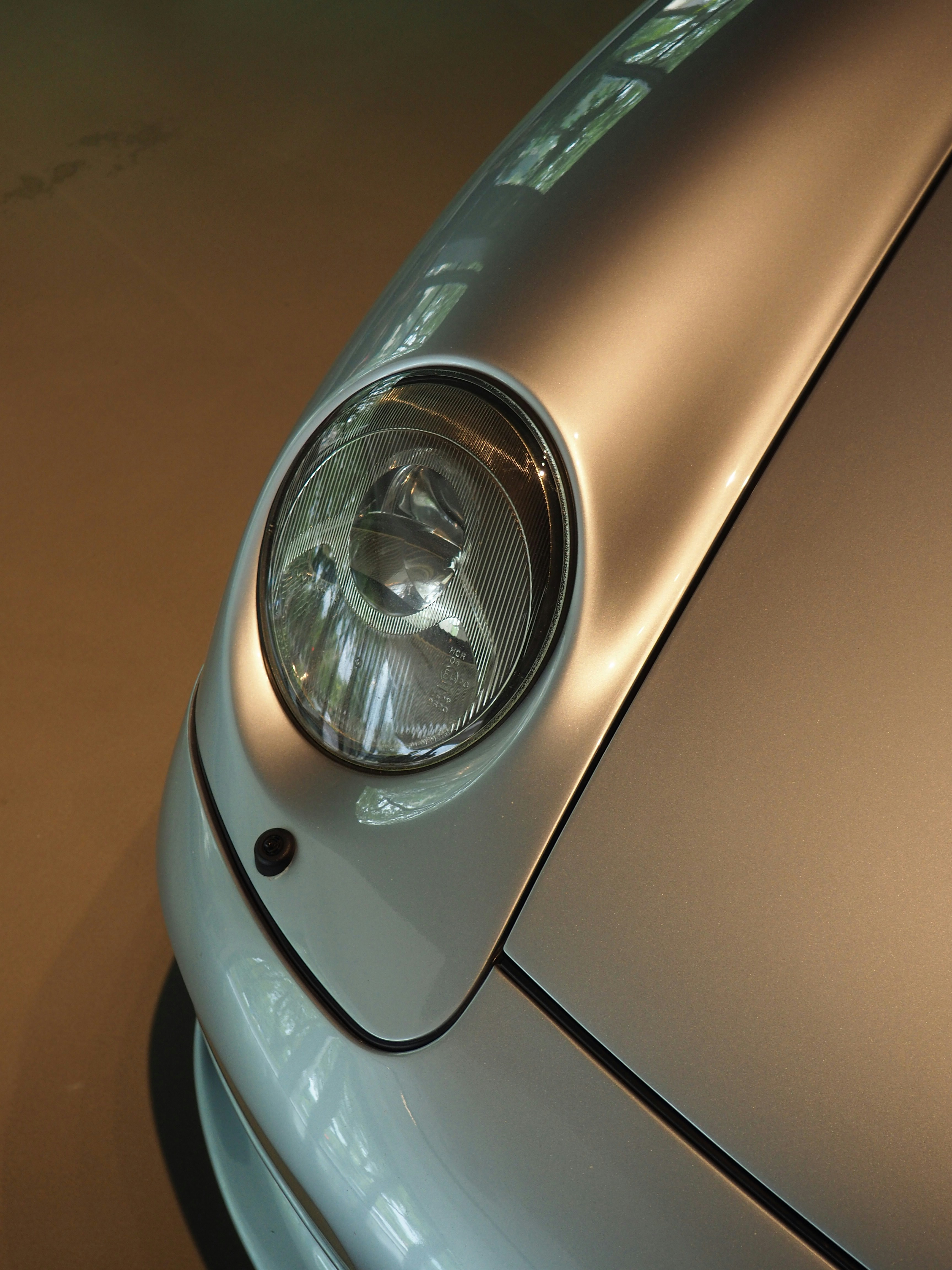 Süßer Blick | Close-up of a silver car headlight