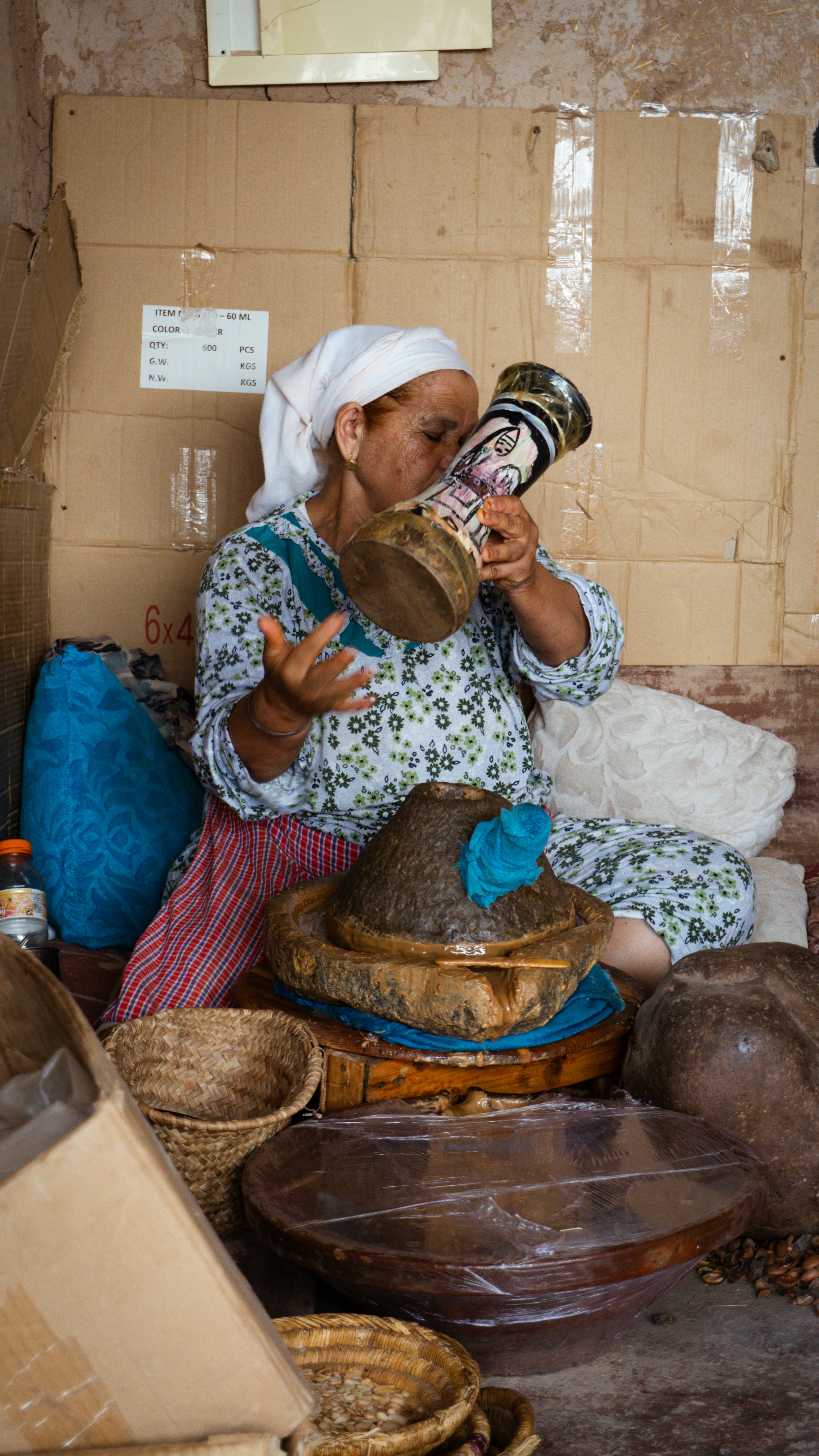 Woman in headscarf holding decorated vase toasting tool