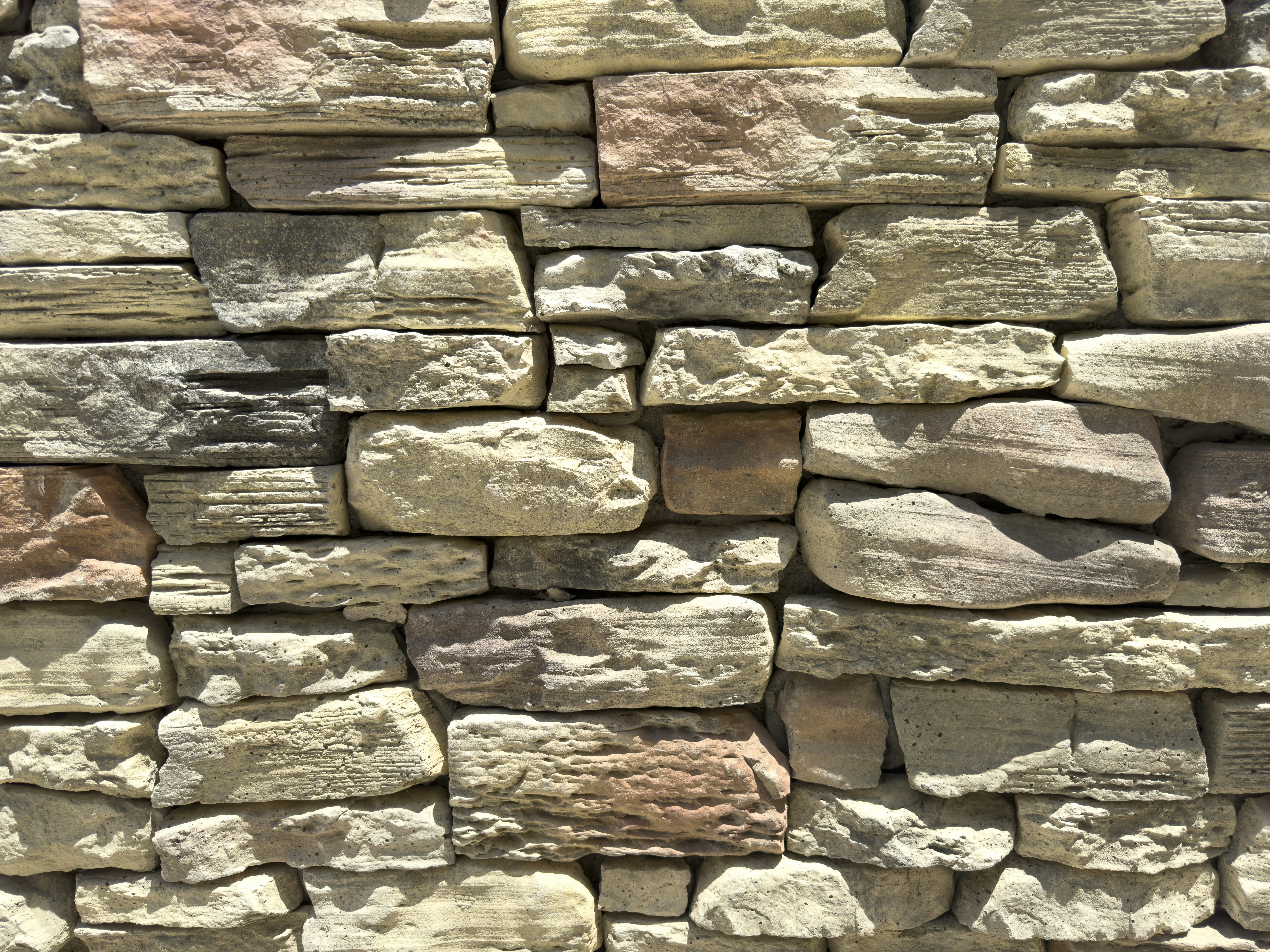 textured stone brick wall surface | A textured wall made of stacked natural stones.
