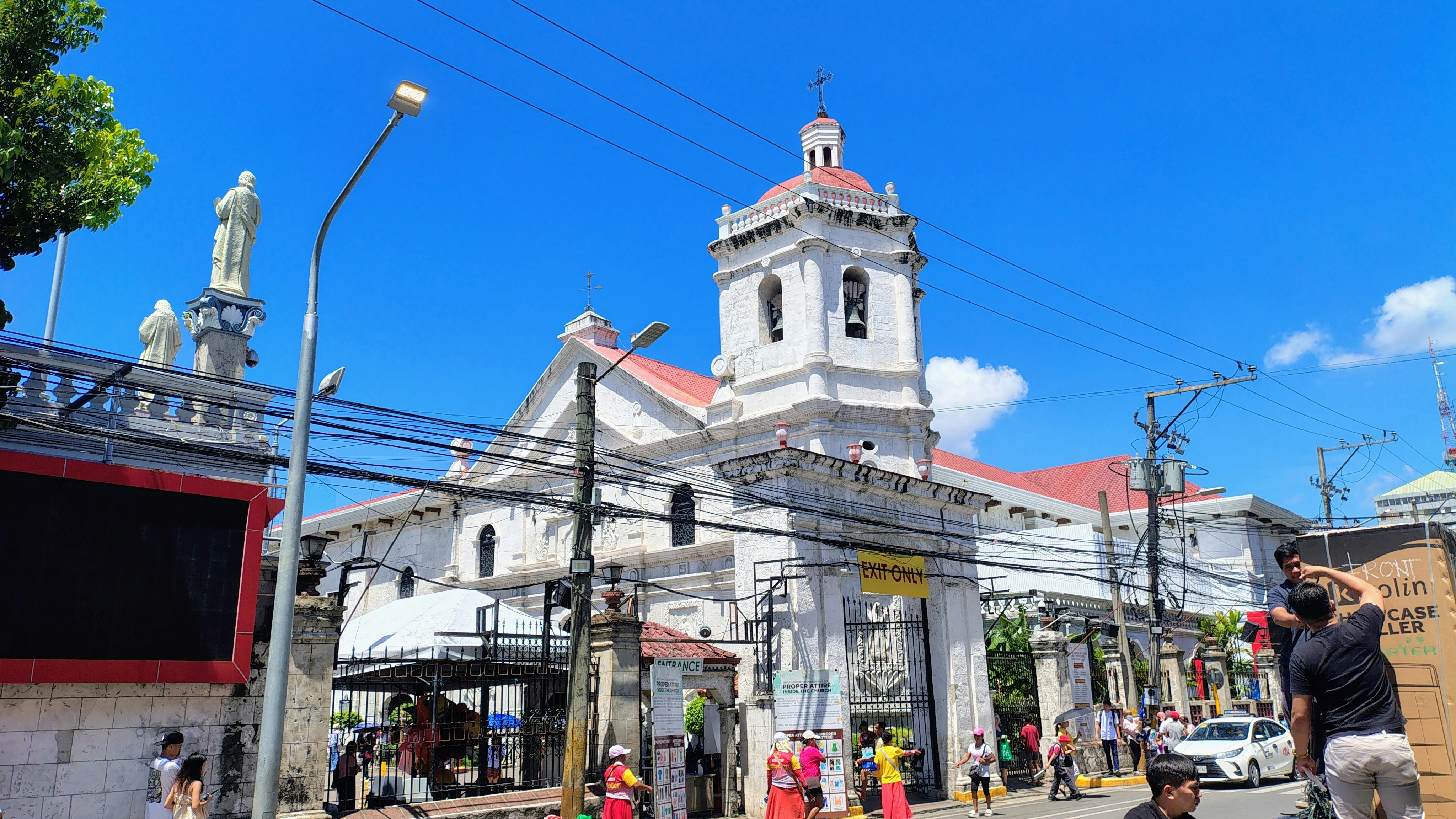 Basilica Minore del Sto. Niño de Cebu, Philippines | White church with a red roof under a blue sky.