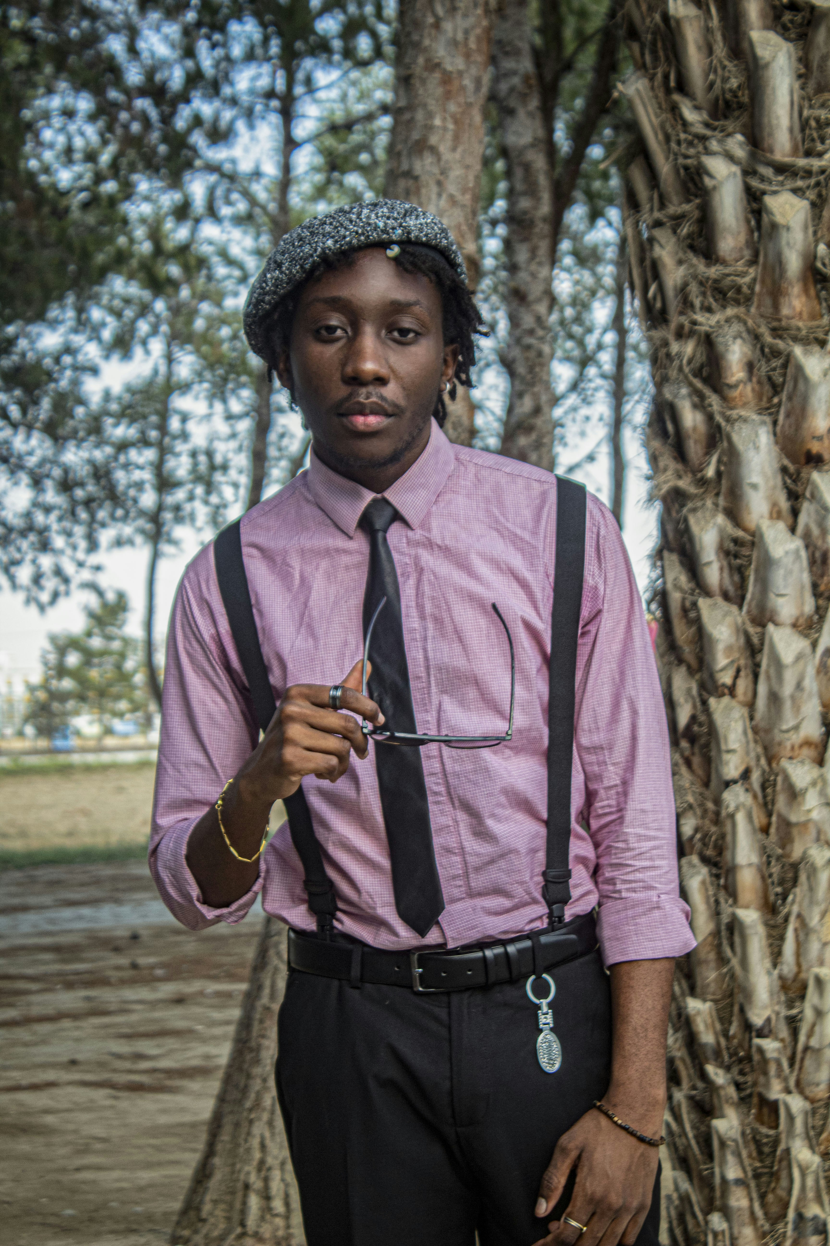 Man in pink shirt, tie, suspenders, and cap