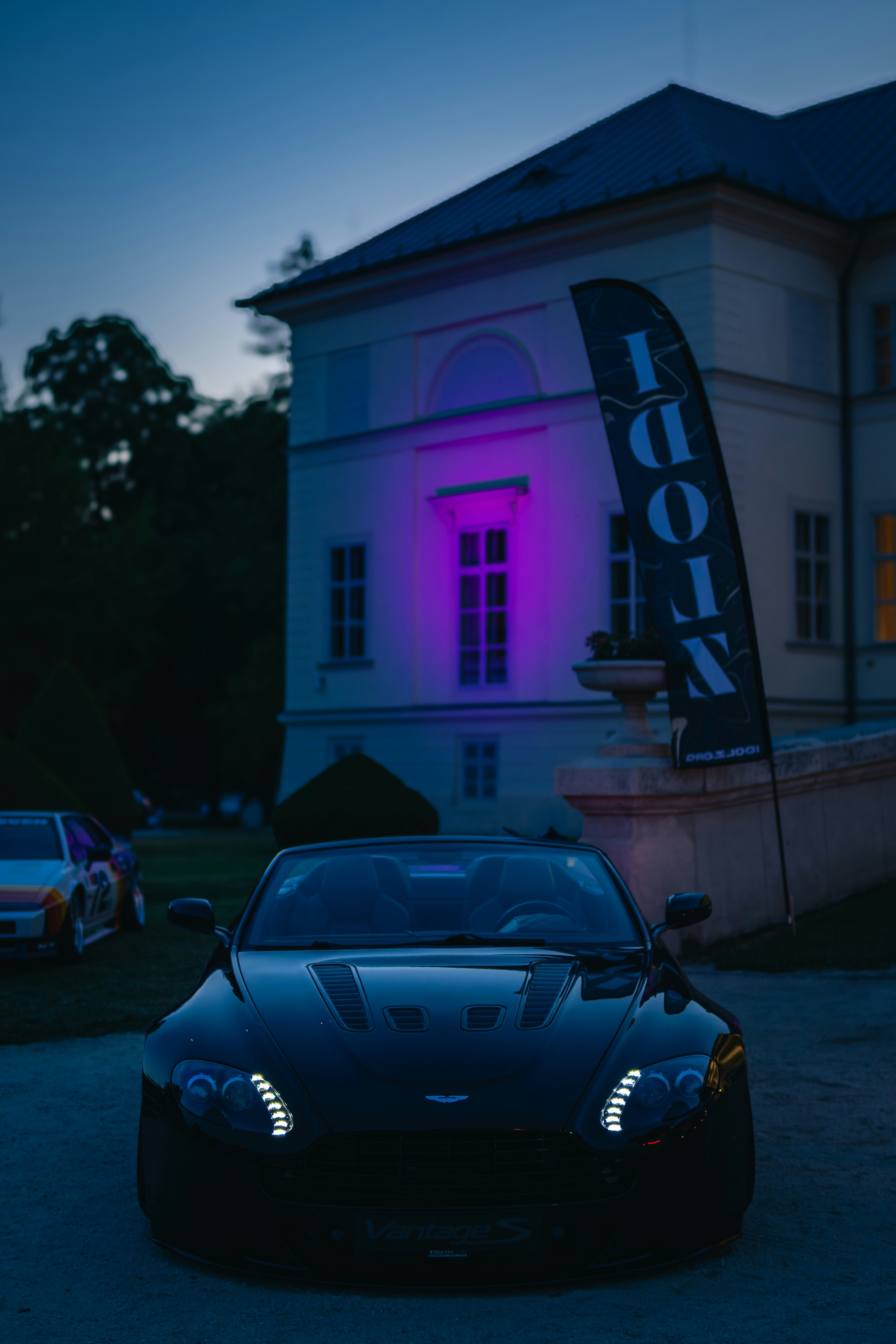 Midnight Serpent: Neon-lit Sports Car Before a Heritage Facade