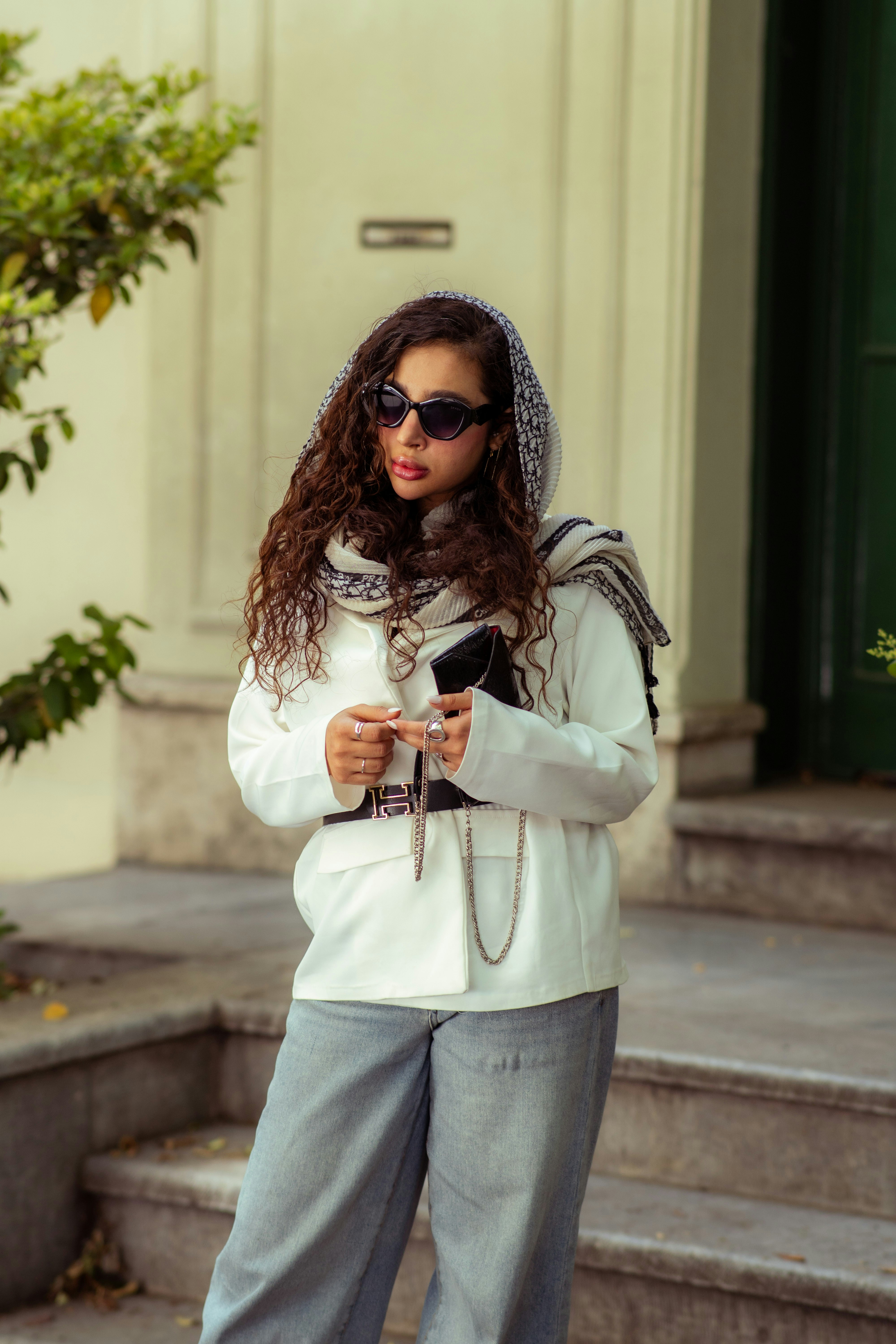 Young woman in sunglasses and scarf outdoors