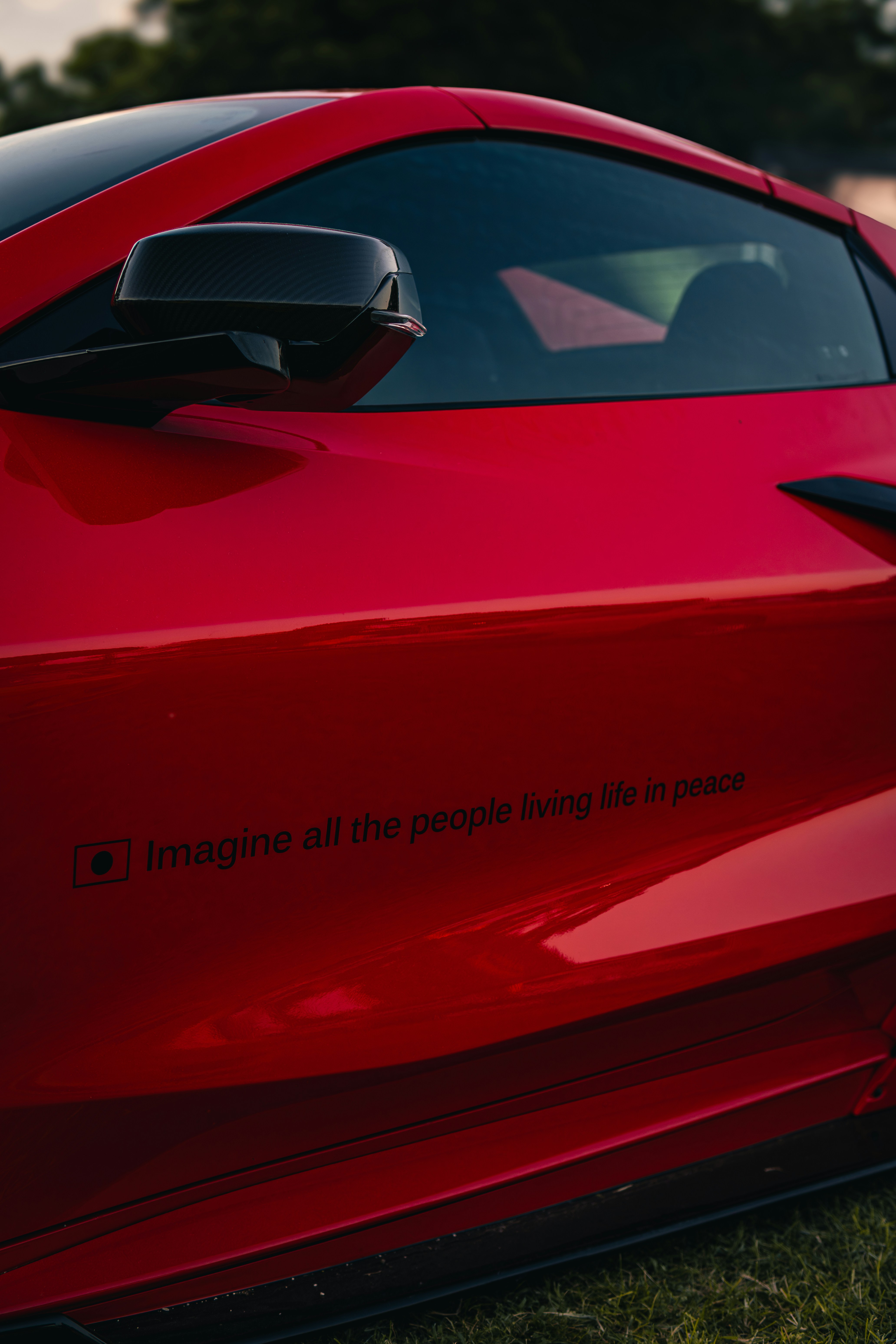 Red sports car with a peace message on door