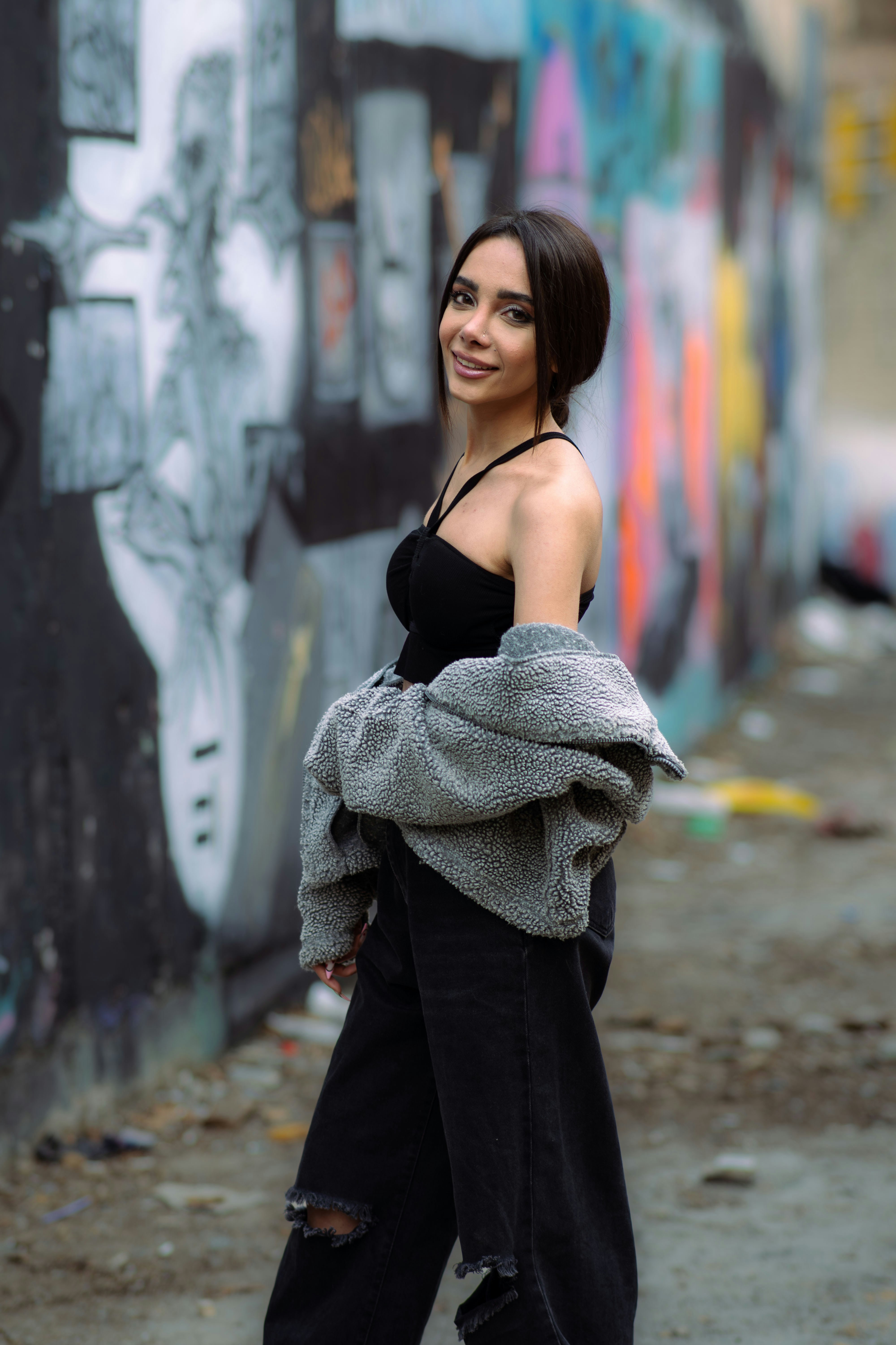 Urban Muse: A Graceful Turn Against a Graffiti Canvas