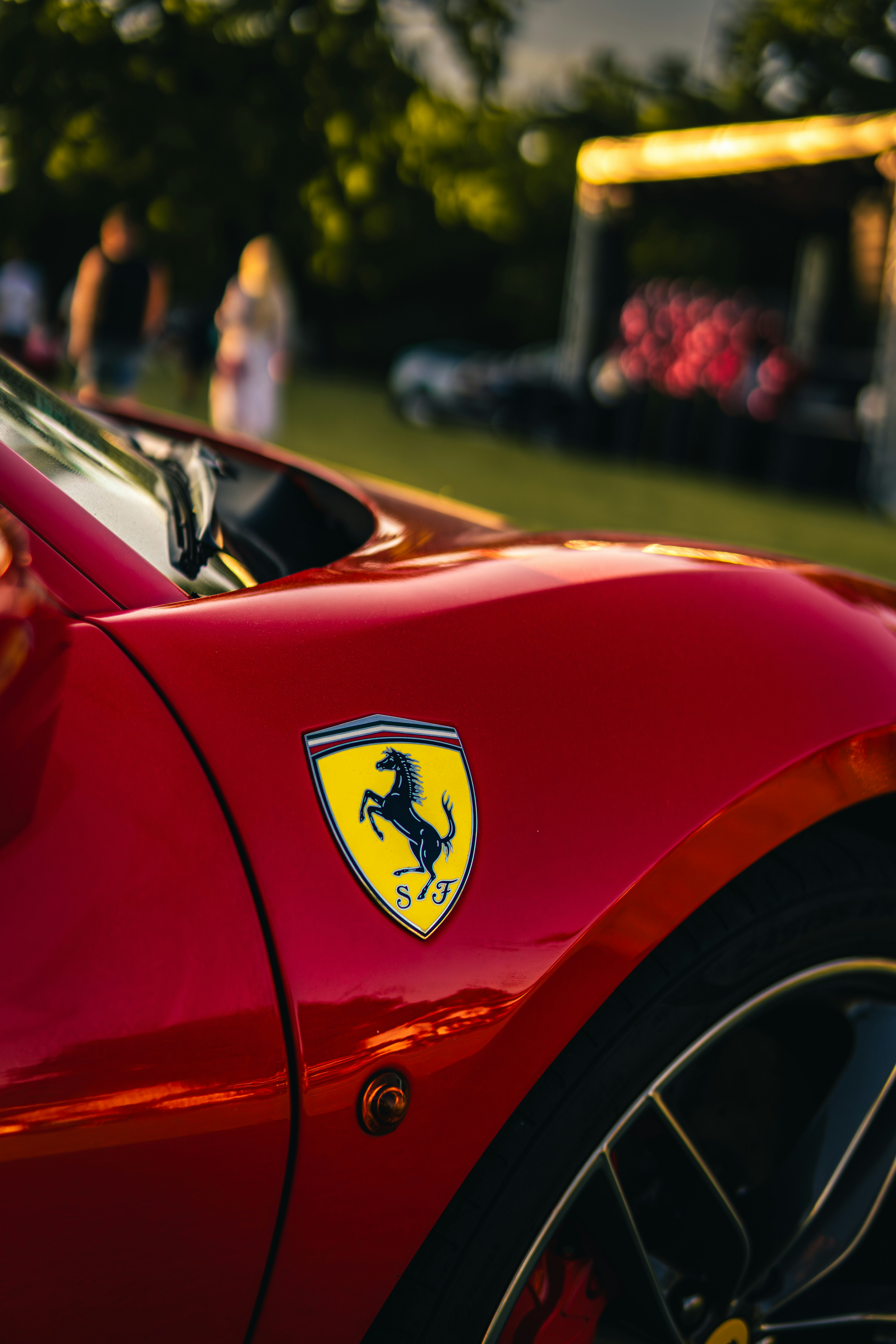 Crimson Crest in Focus: Ferrari Emblem on a Sunlit Coupe