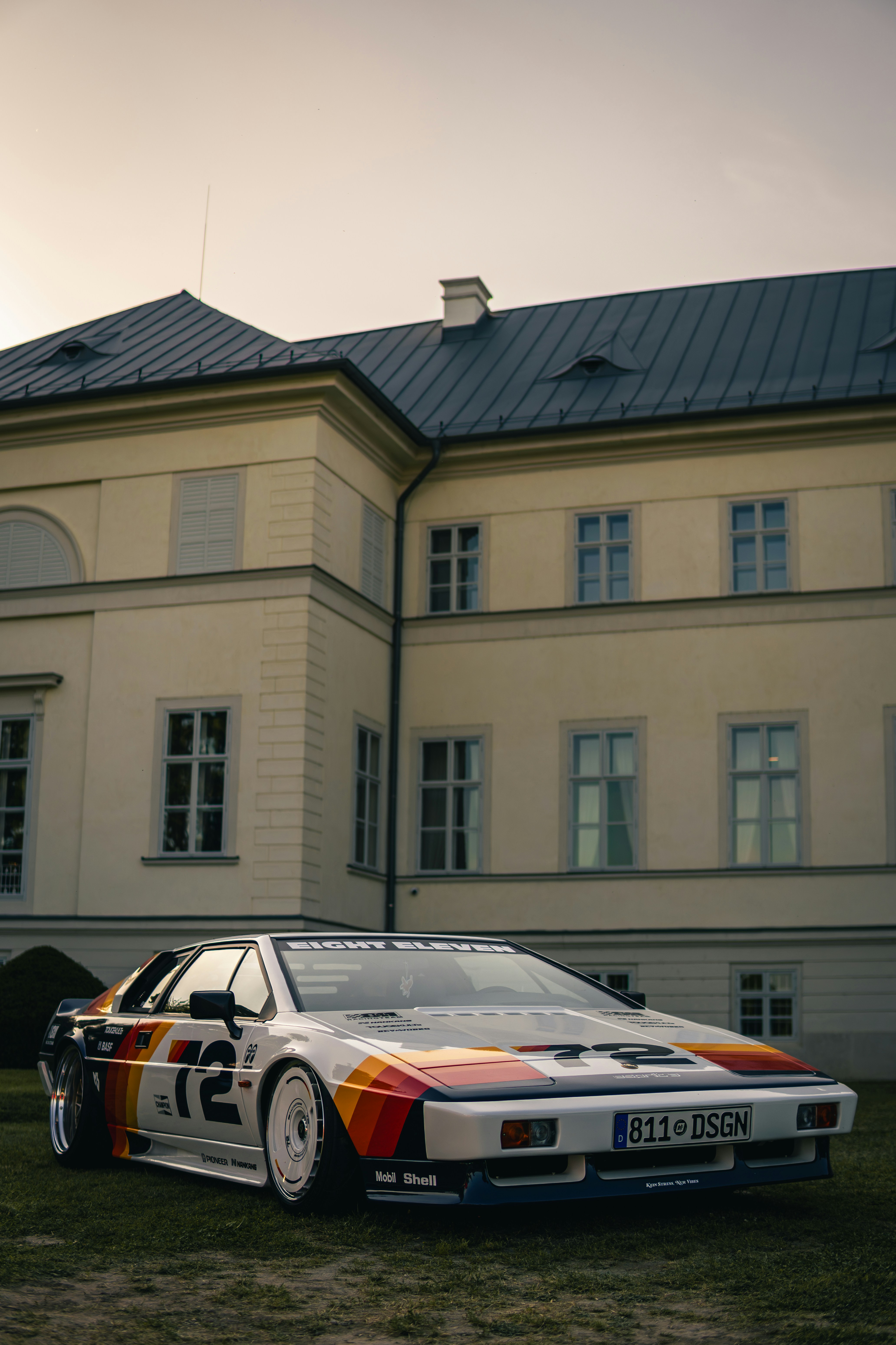 Number 12 in the Grass: A Vintage Racer Resting Before a Neoclassical Building
