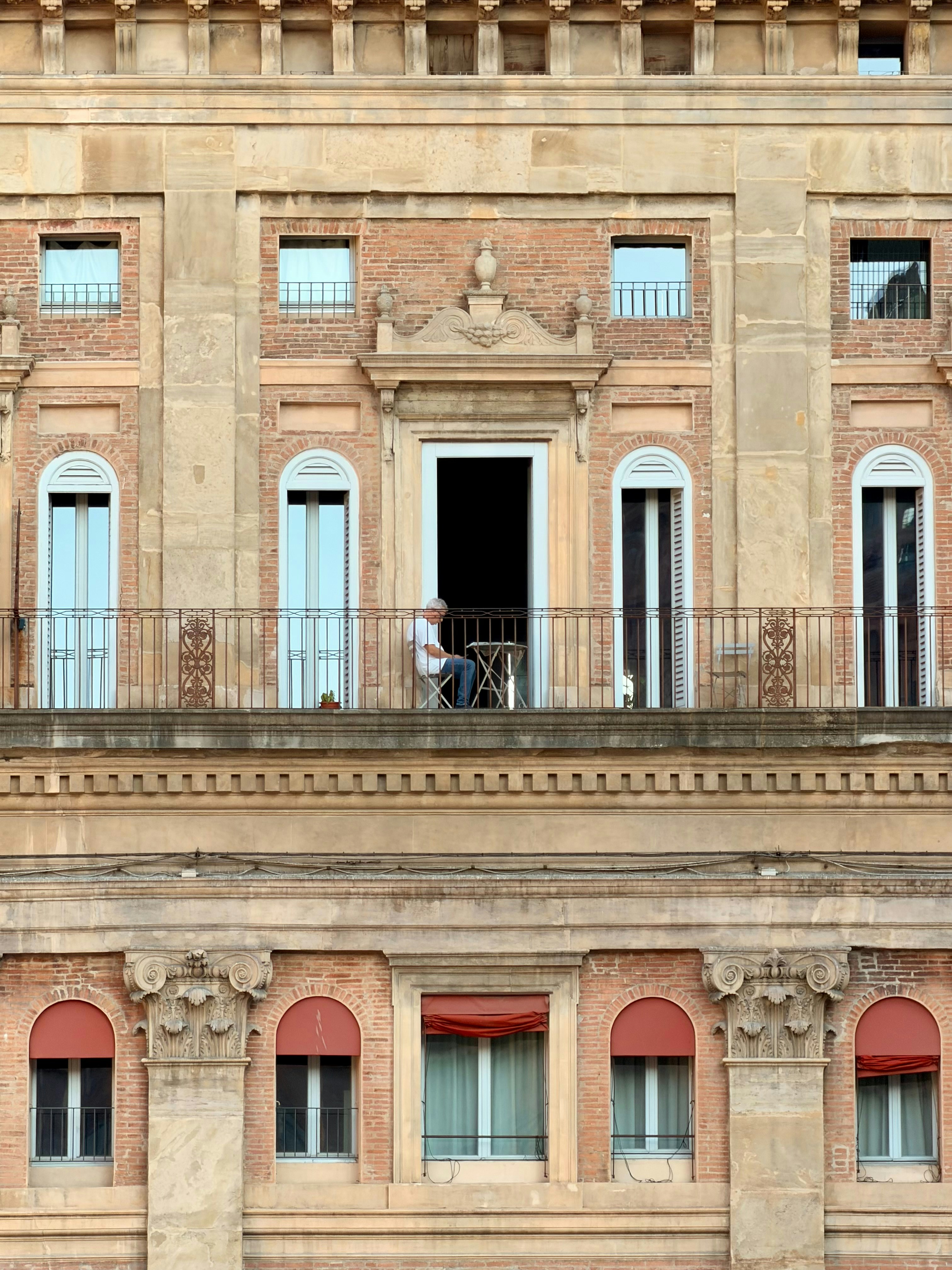 Facade of Time: Balcony Portrait on a Historic Brick Canvas