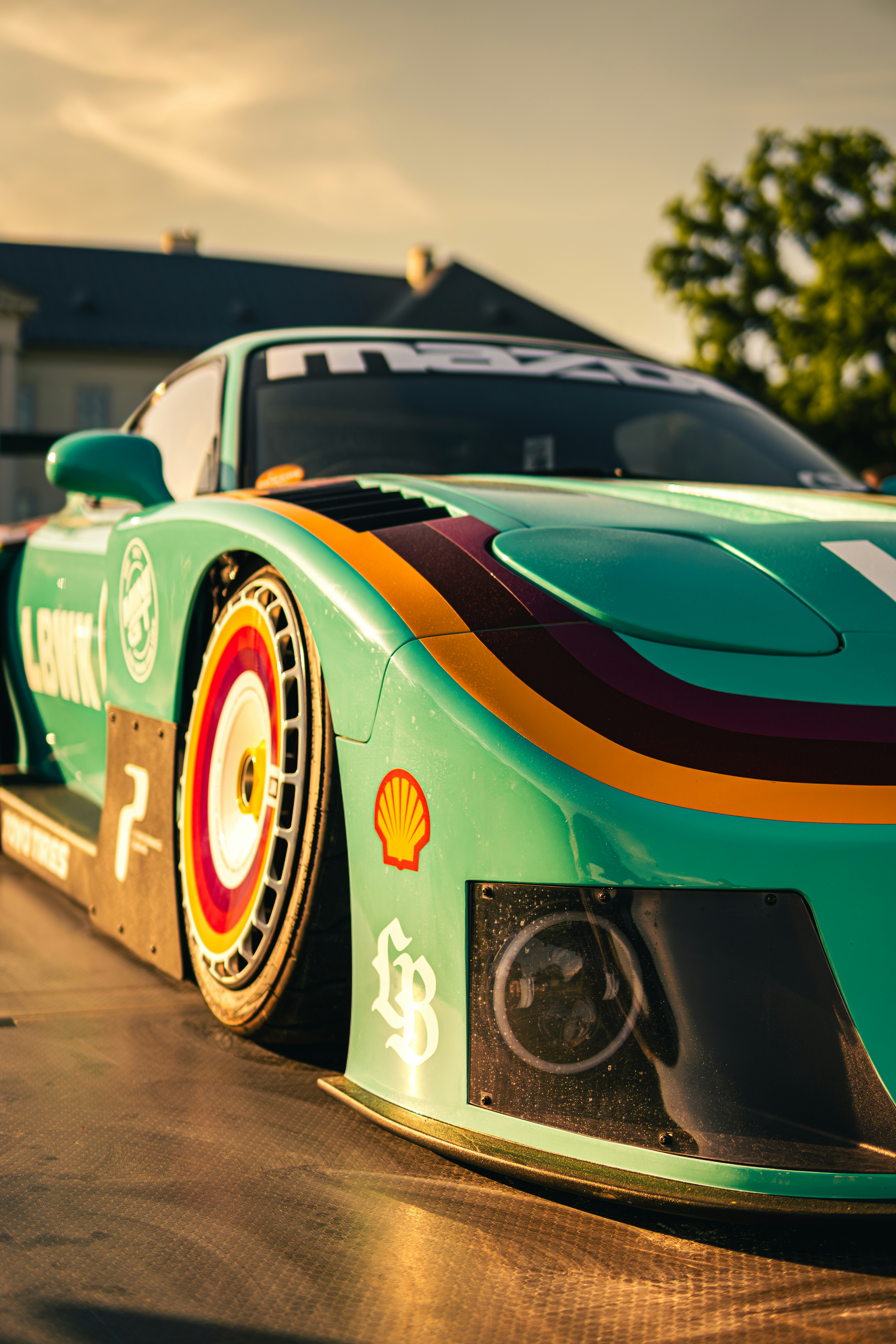  turquoise race car bites into golden hour light, chrome accents gleaming