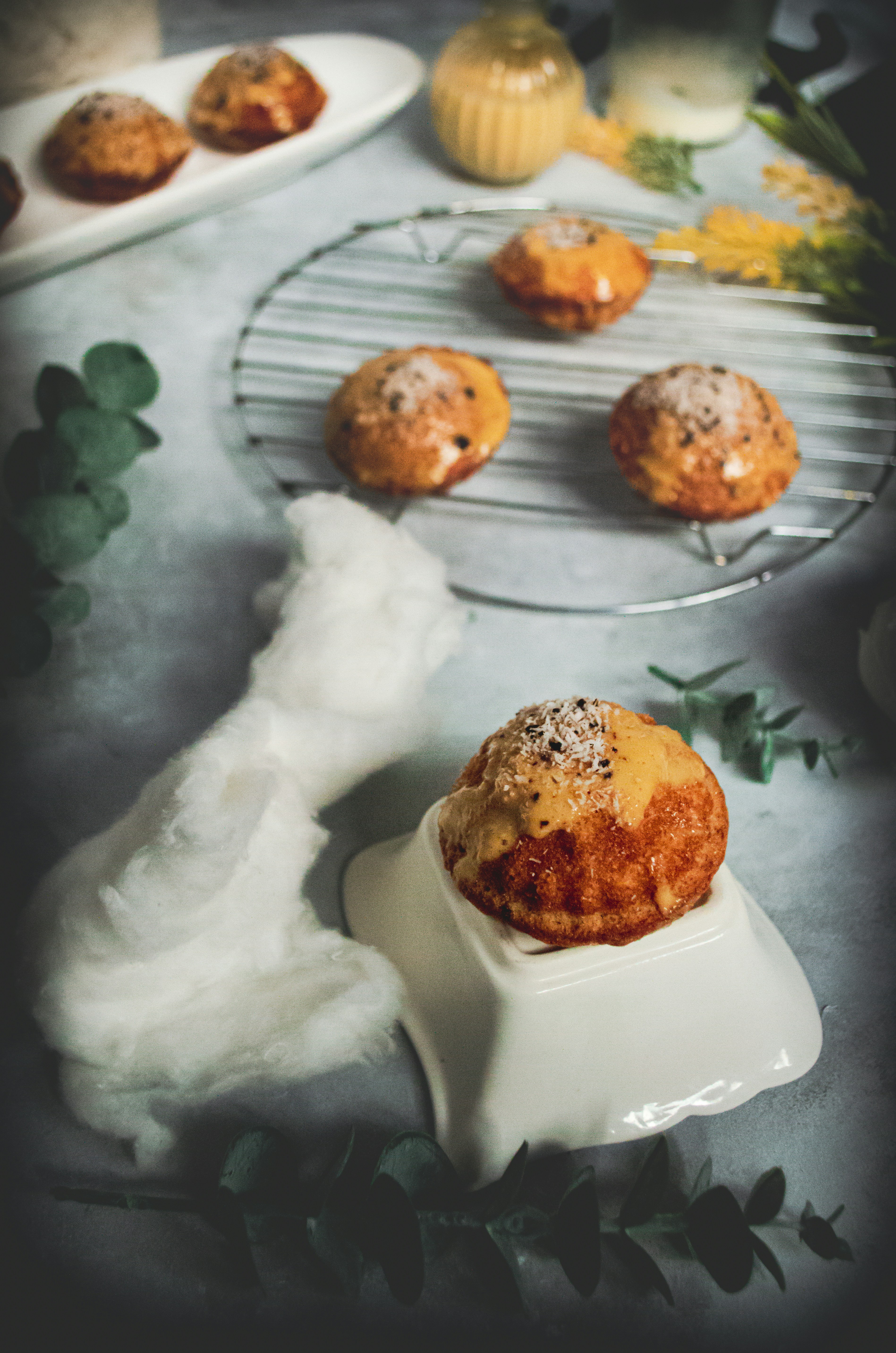 Muffins with powdered sugar on a cooling rack.