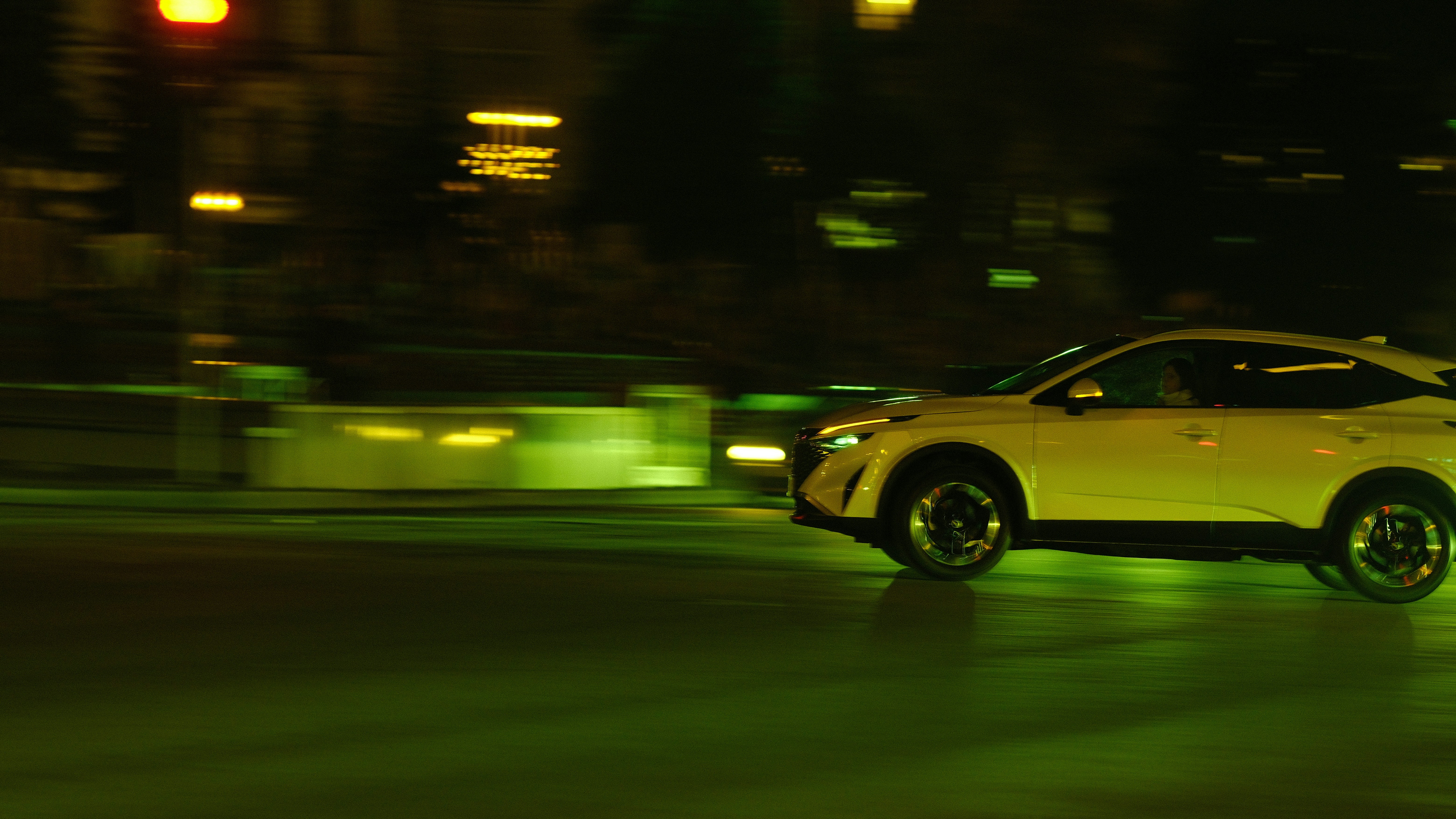 White car driving on a road at night