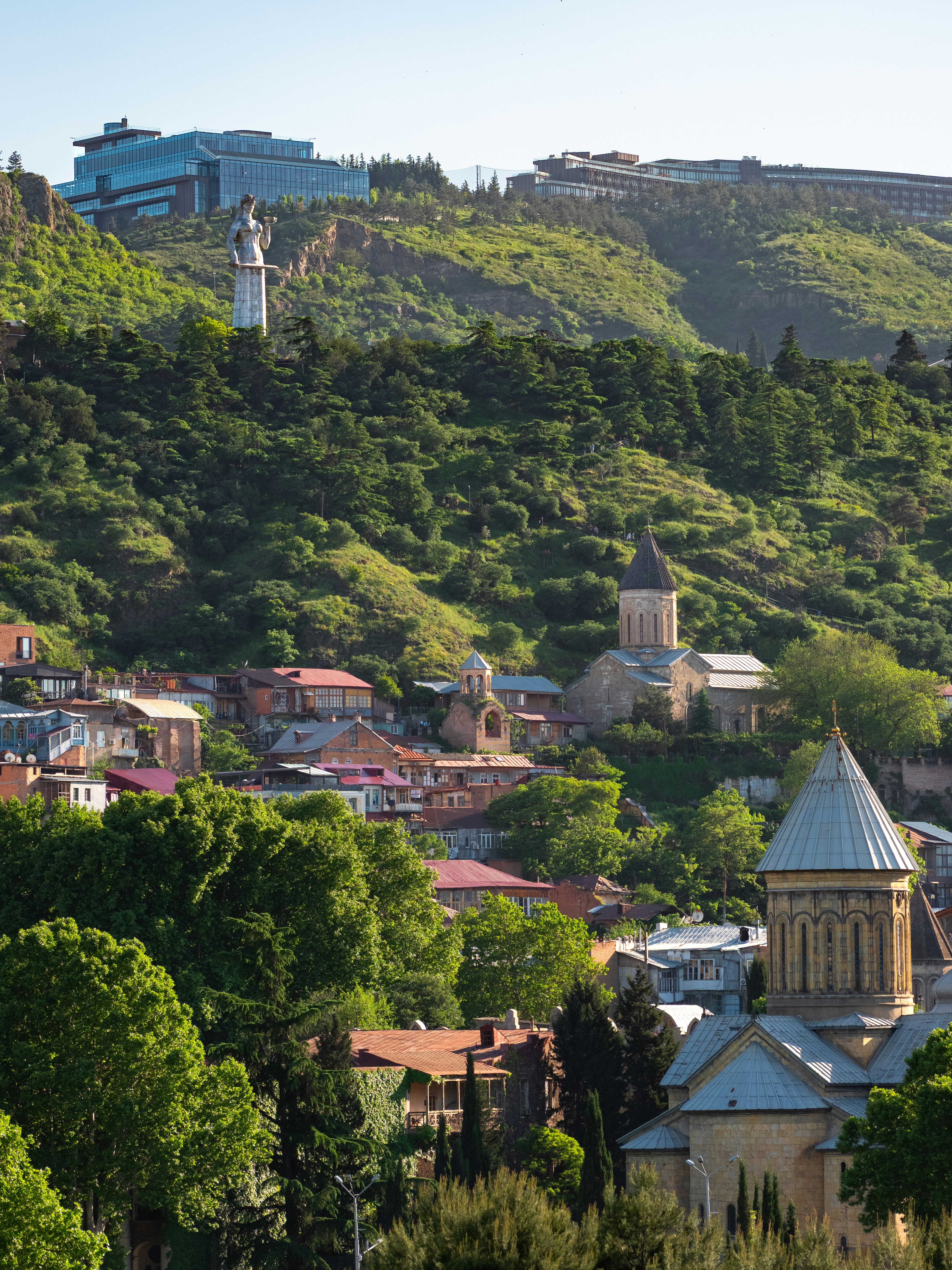 Tbilisi cityscape with historic churches and modern buildings.