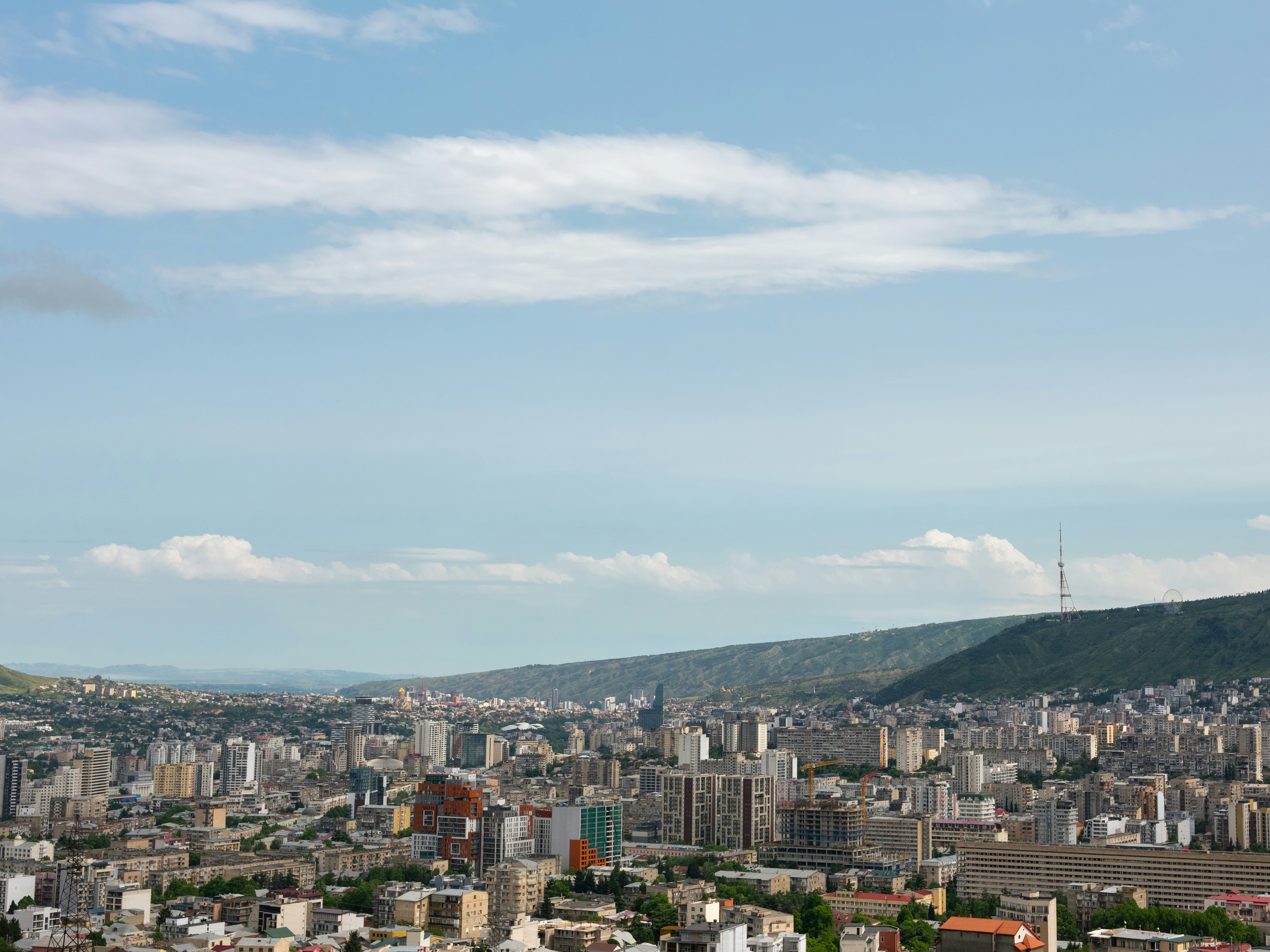Panoramic view of a sprawling city with distant mountains.
