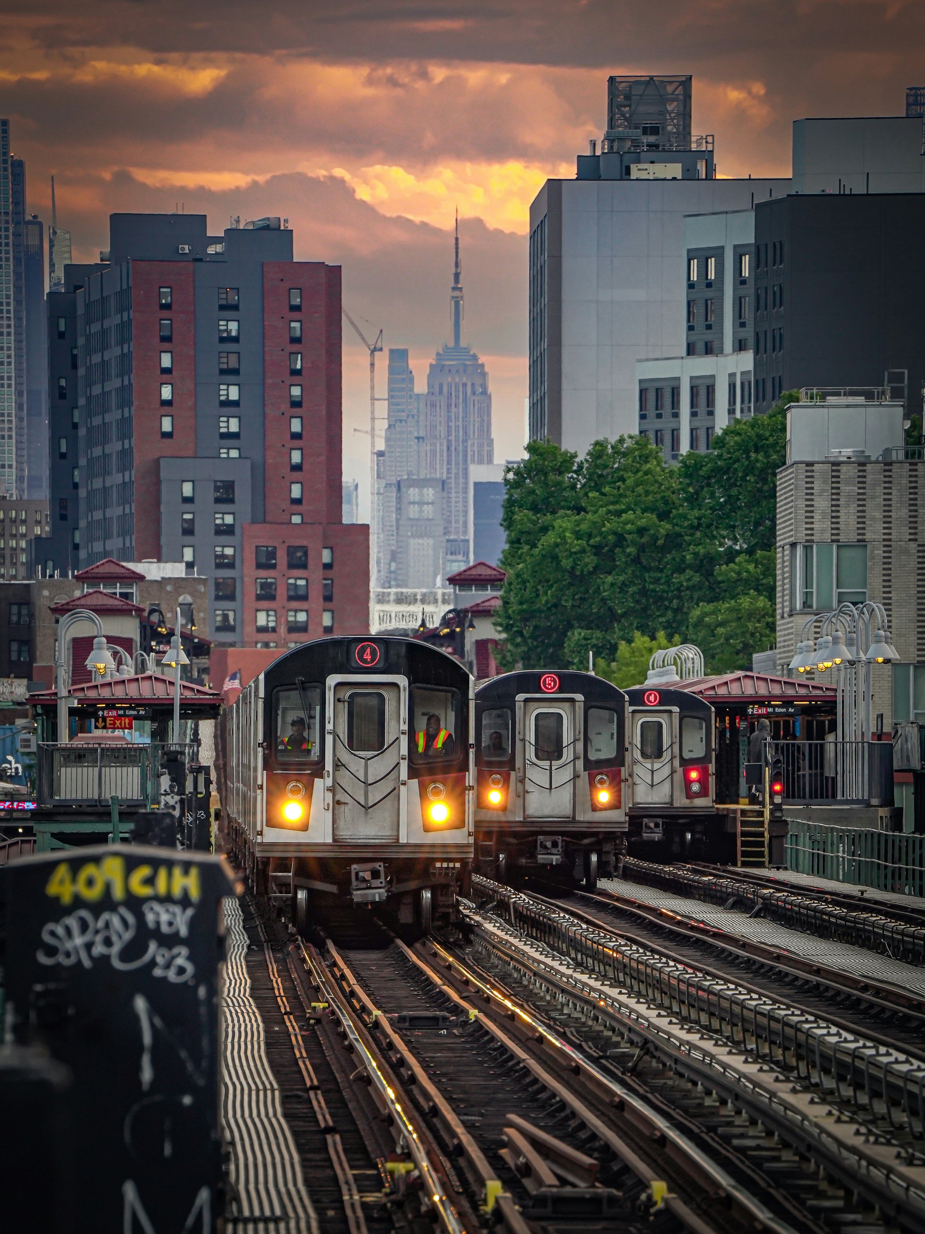 The Empire Strikes Back - SMNYCMan | Trains on elevated tracks with city skyline at sunset