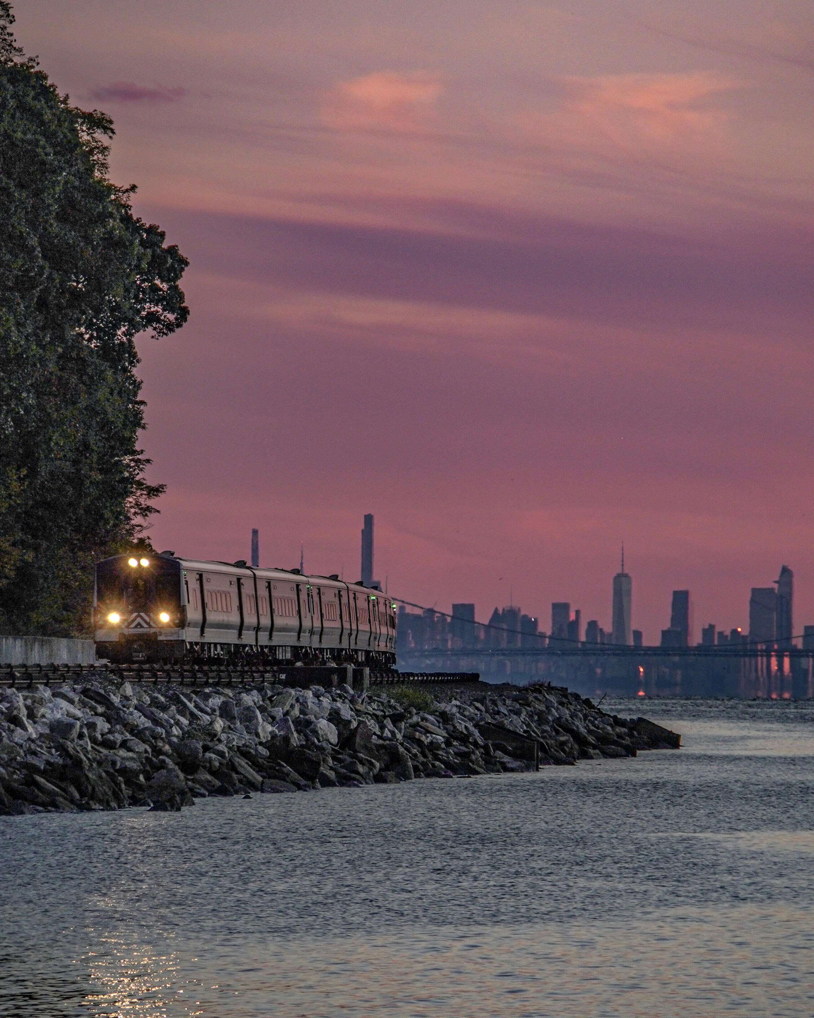 Dusk Freight: A Pink-Hued Skyline Framed by a Train on the Waterfront