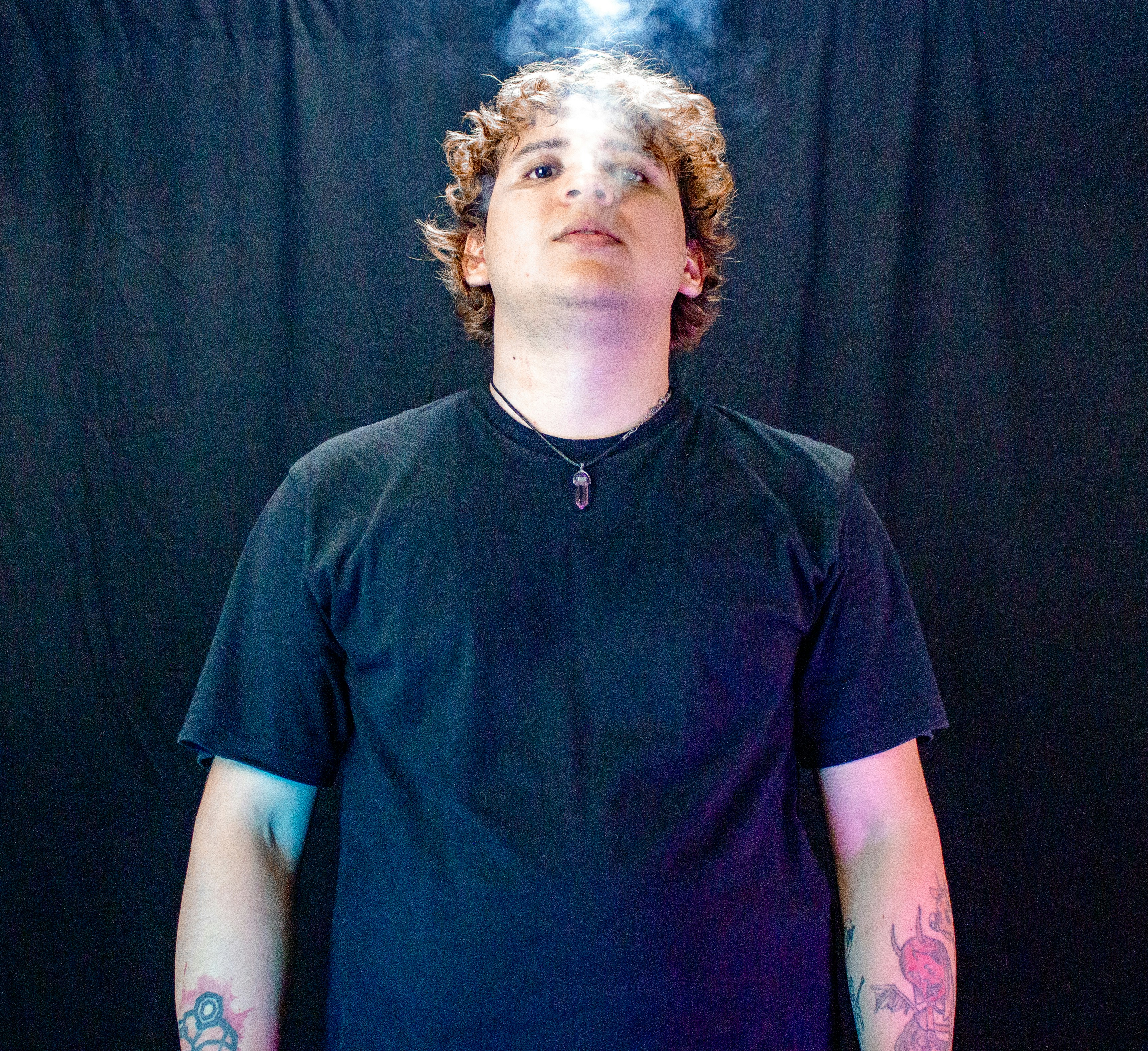 Centered Presence Beneath Cyan-Purple Studio Smoke