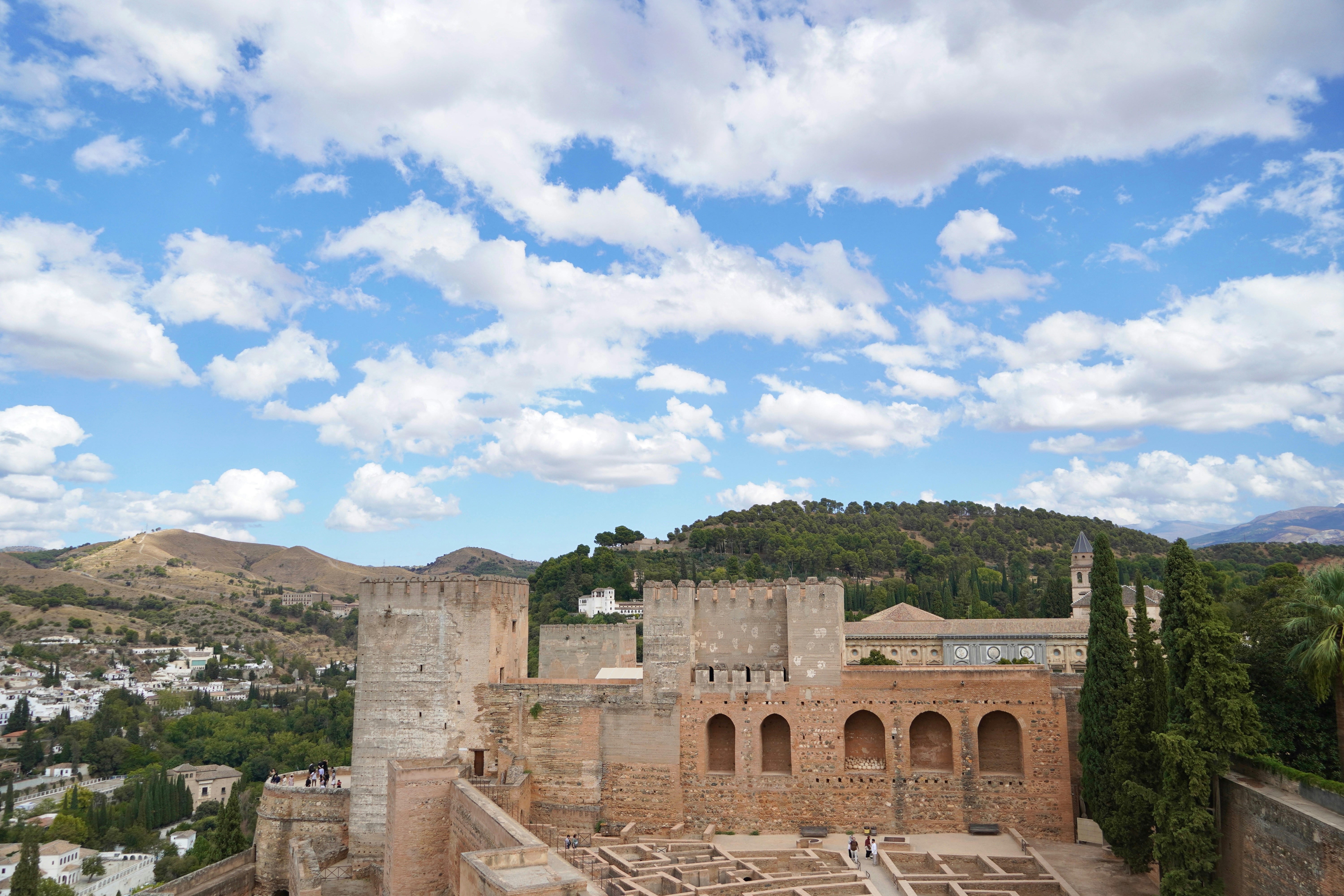 Ancient fortress ruins under a cloudy blue sky.