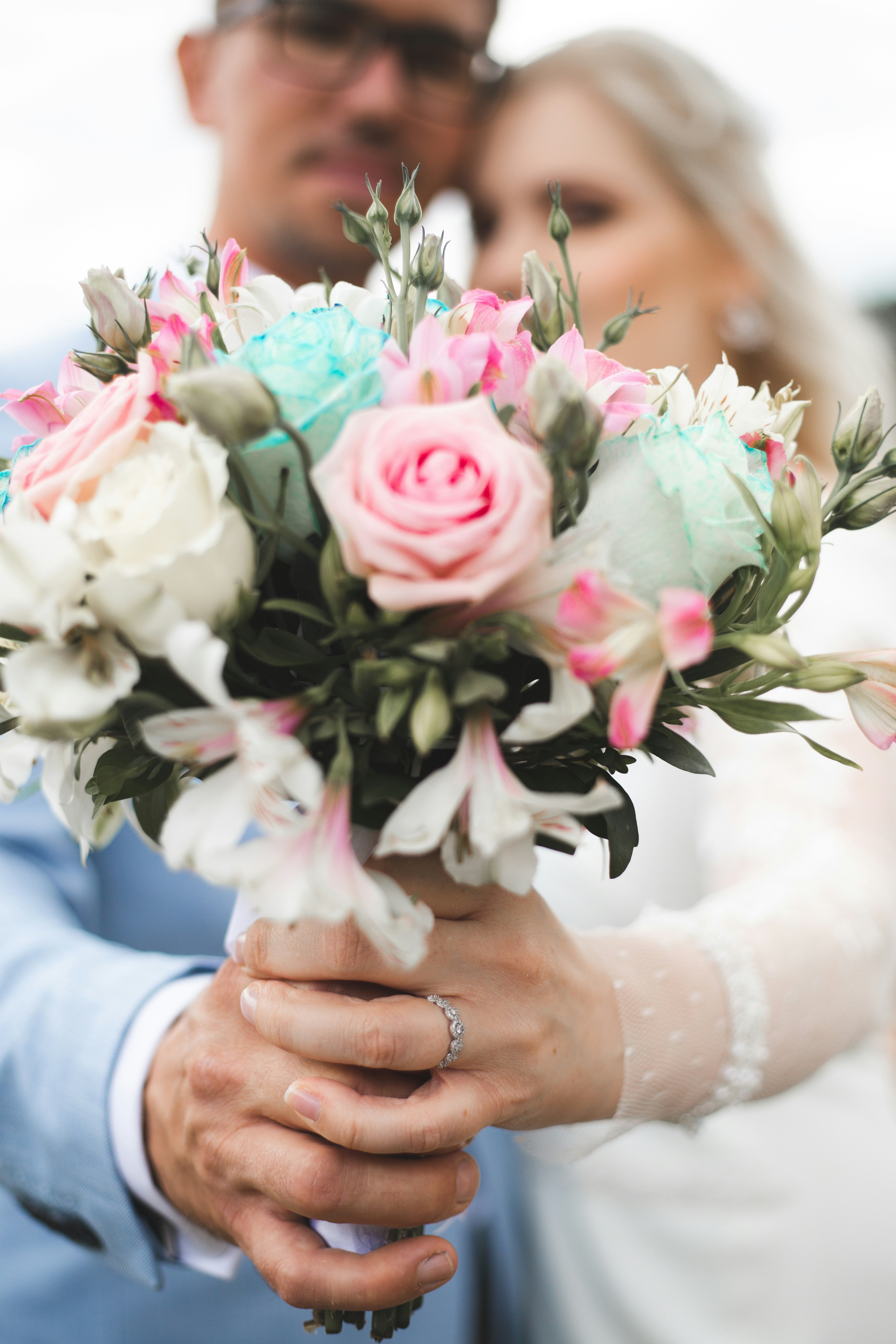 Flower bouquet held by woman and her fiance. | Couple holding a wedding bouquet