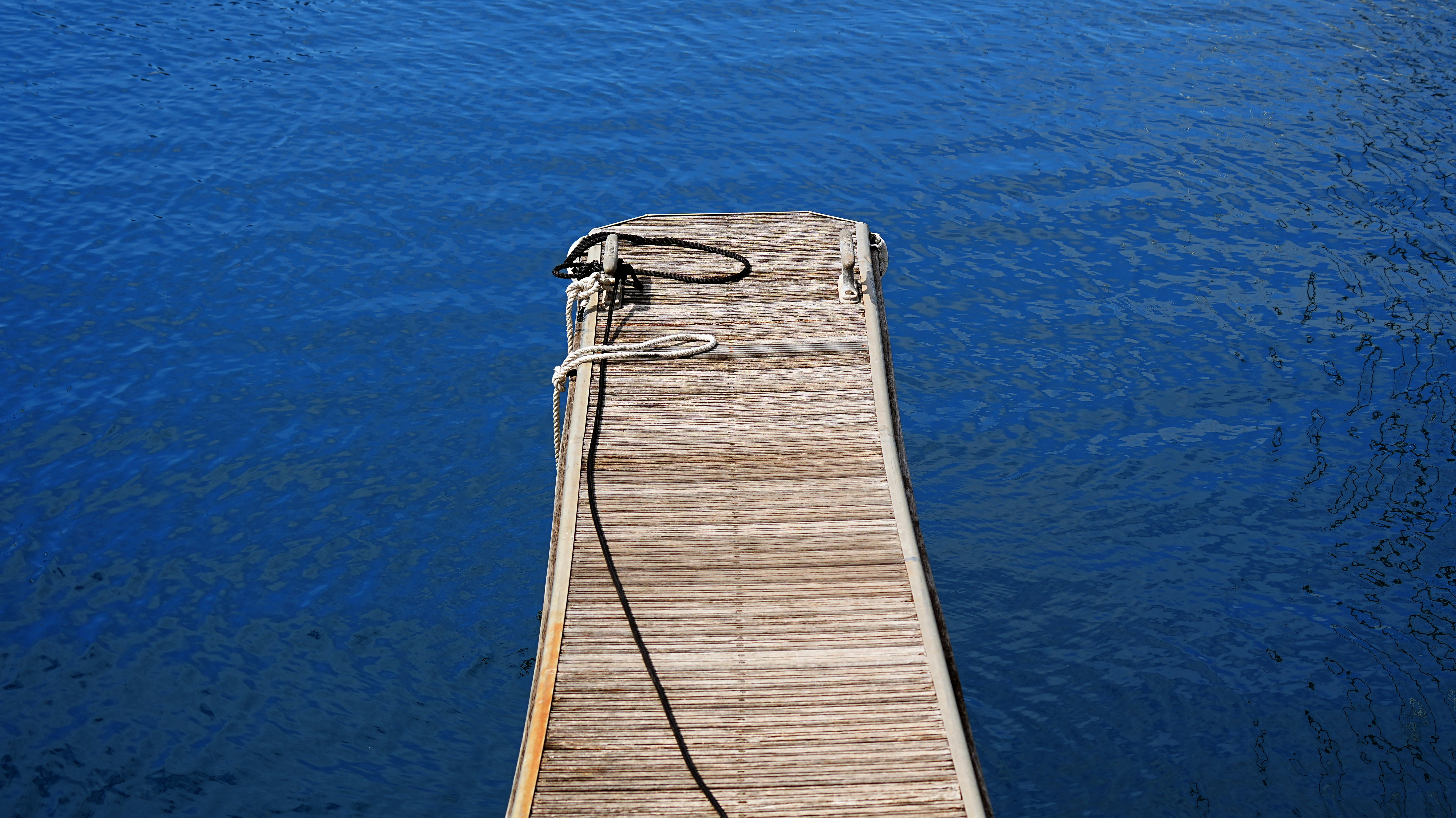 Wooden pier extending into deep blue water