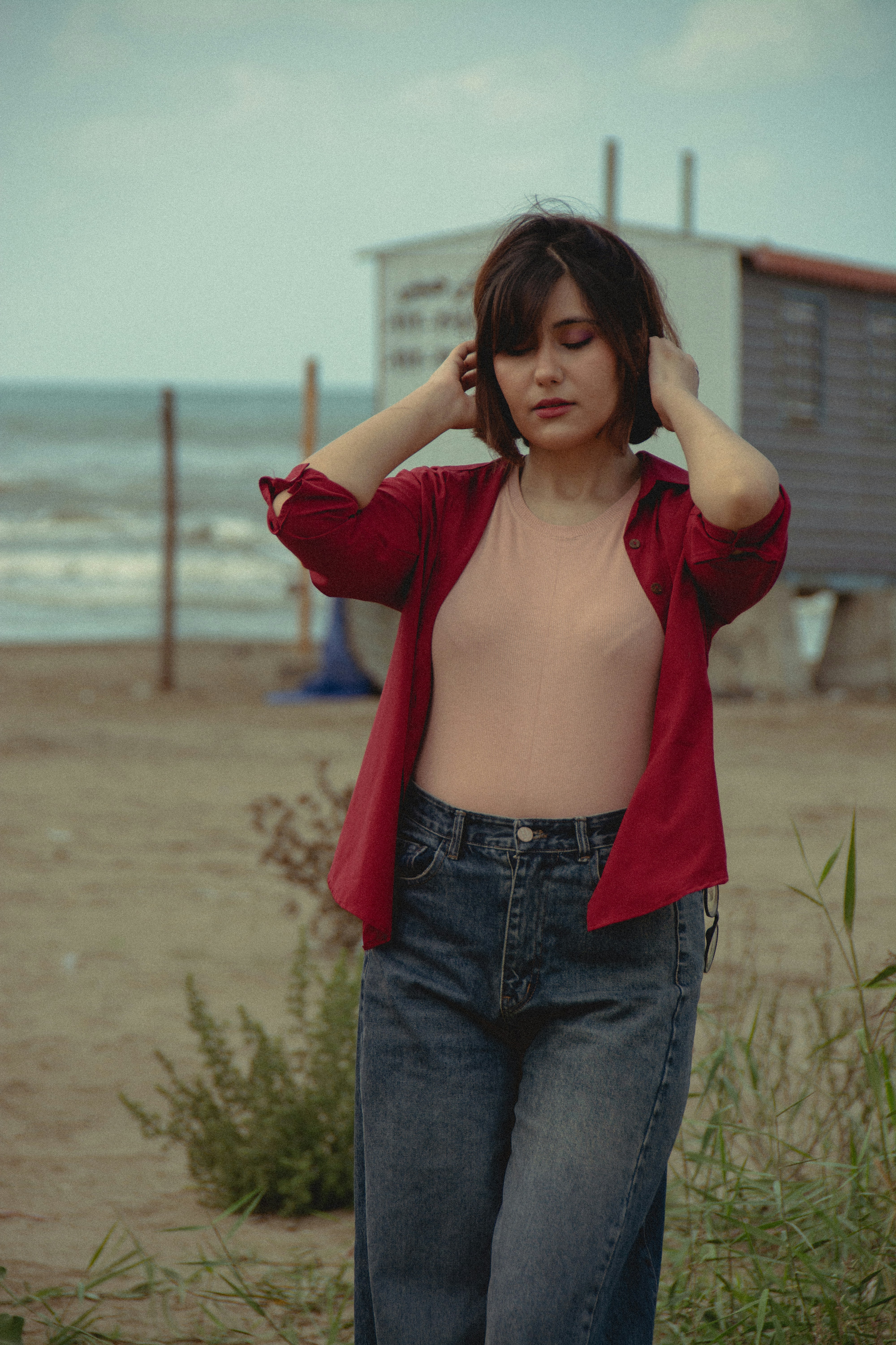 Woman in red shirt and jeans on a beach