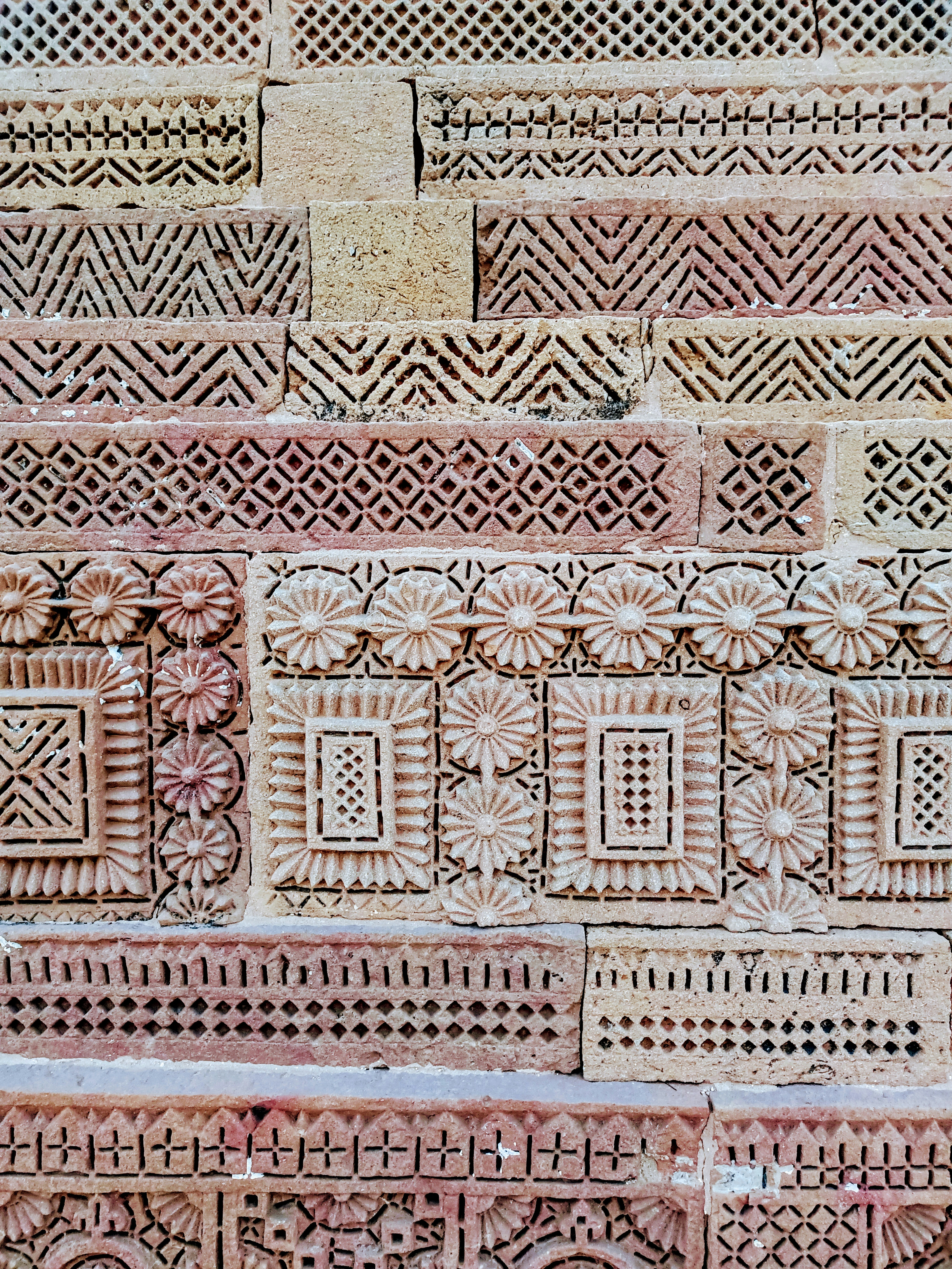Intricate carved stone patterns on an ancient wall.