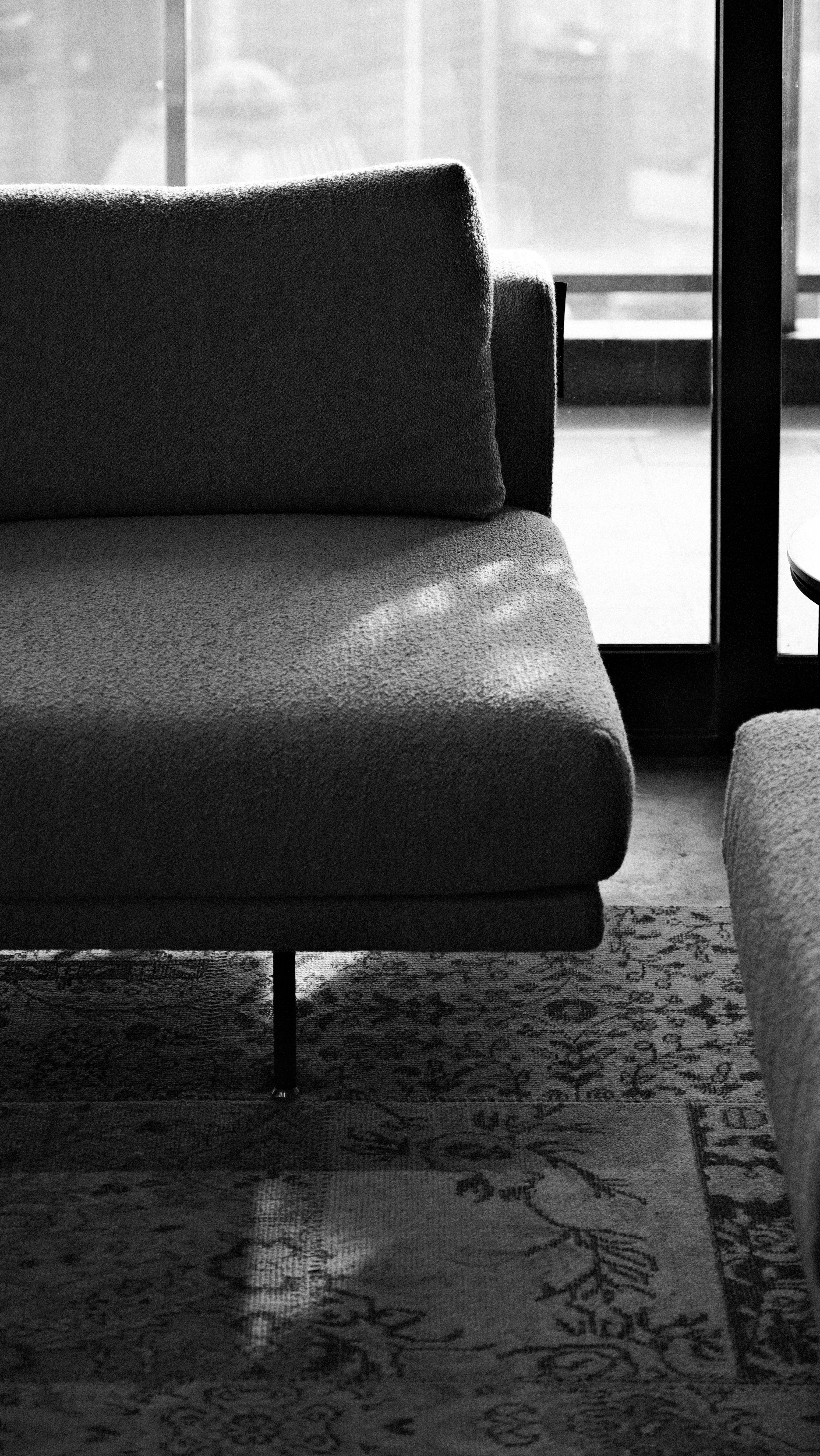 Sofa with patterned rug and sunlight