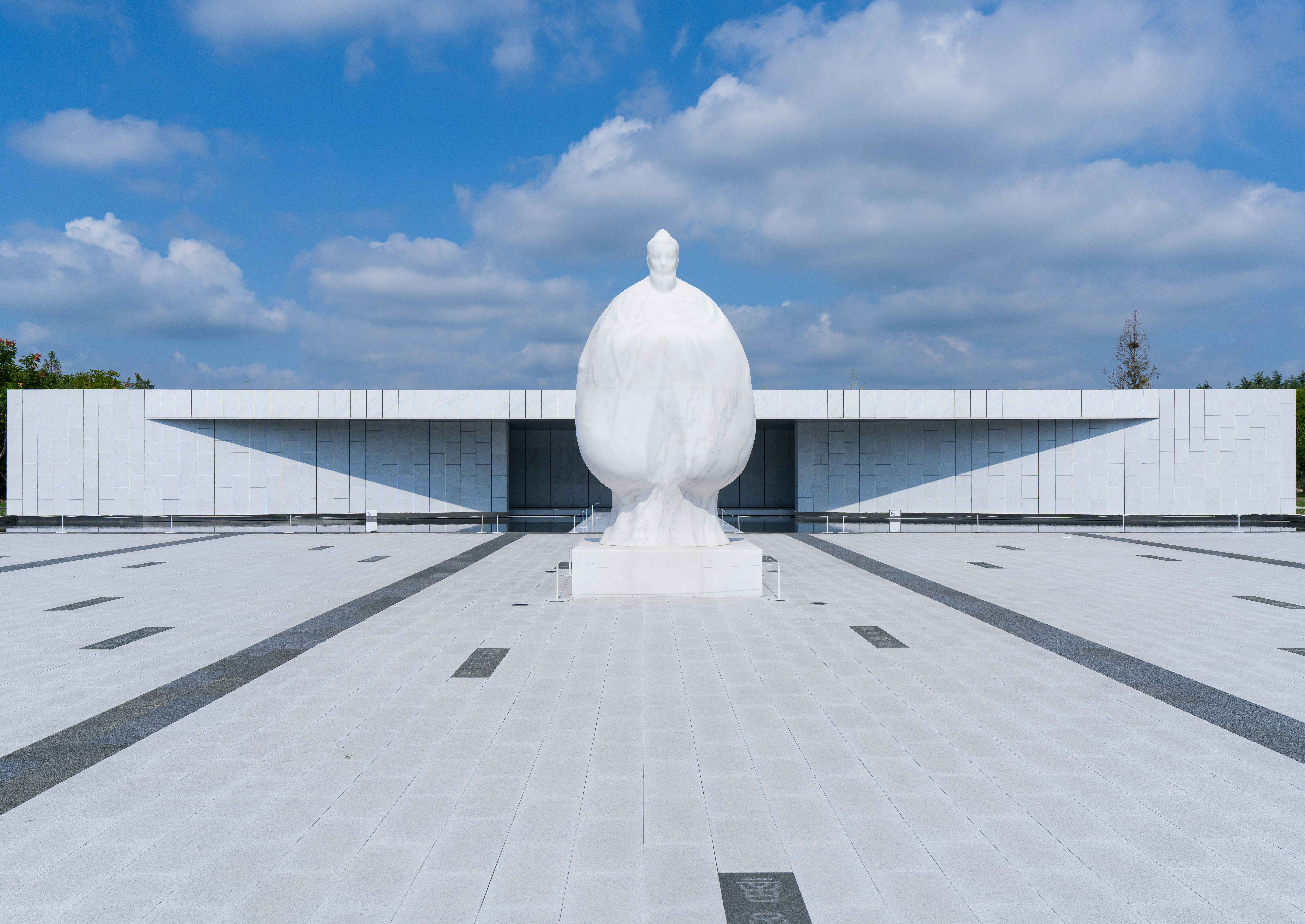 Monolithic White Sentinel at the Center of a Geometric Plaza