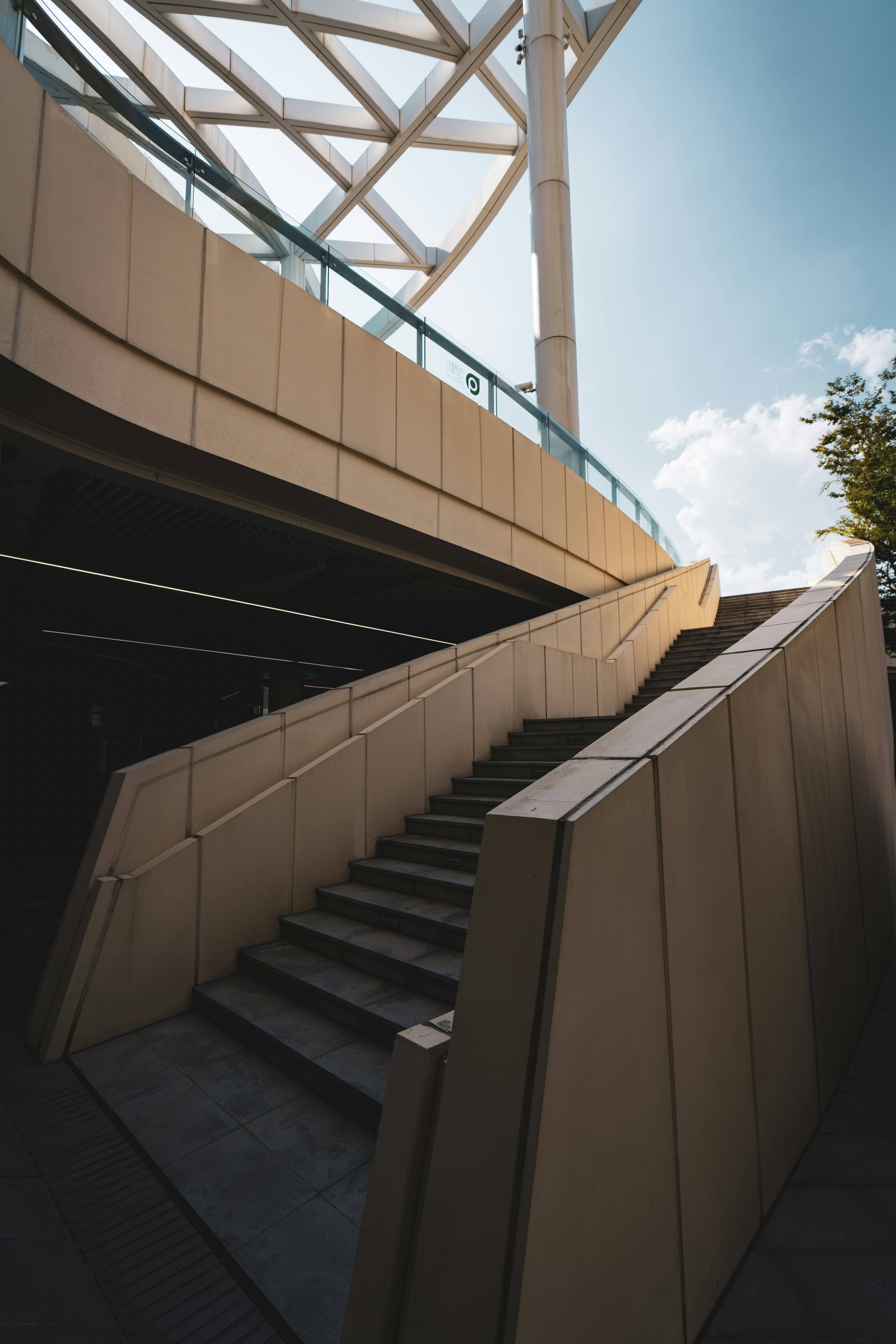 Modern concrete staircase leading upwards under a structure