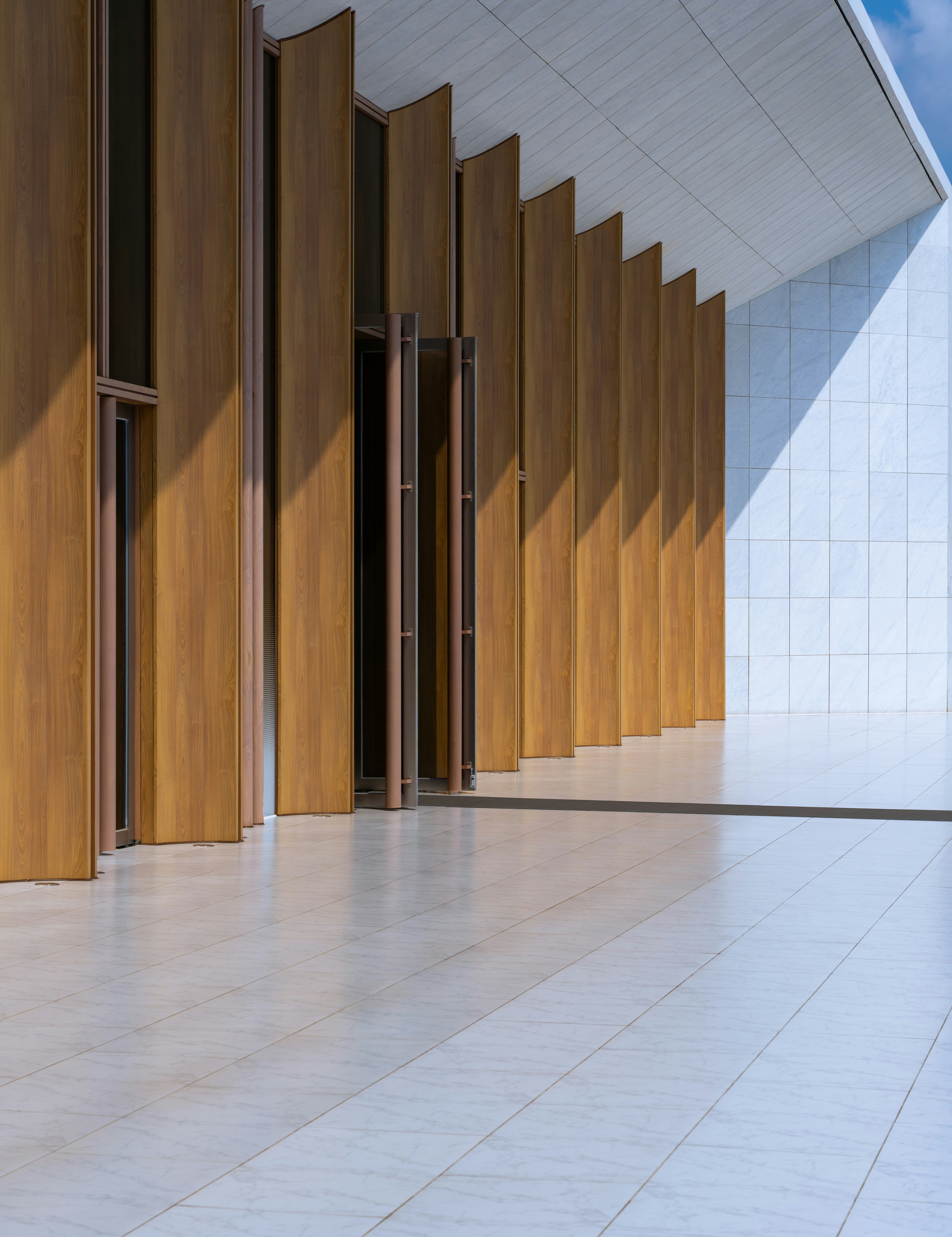 Modern building facade with wooden panels and marble floor.