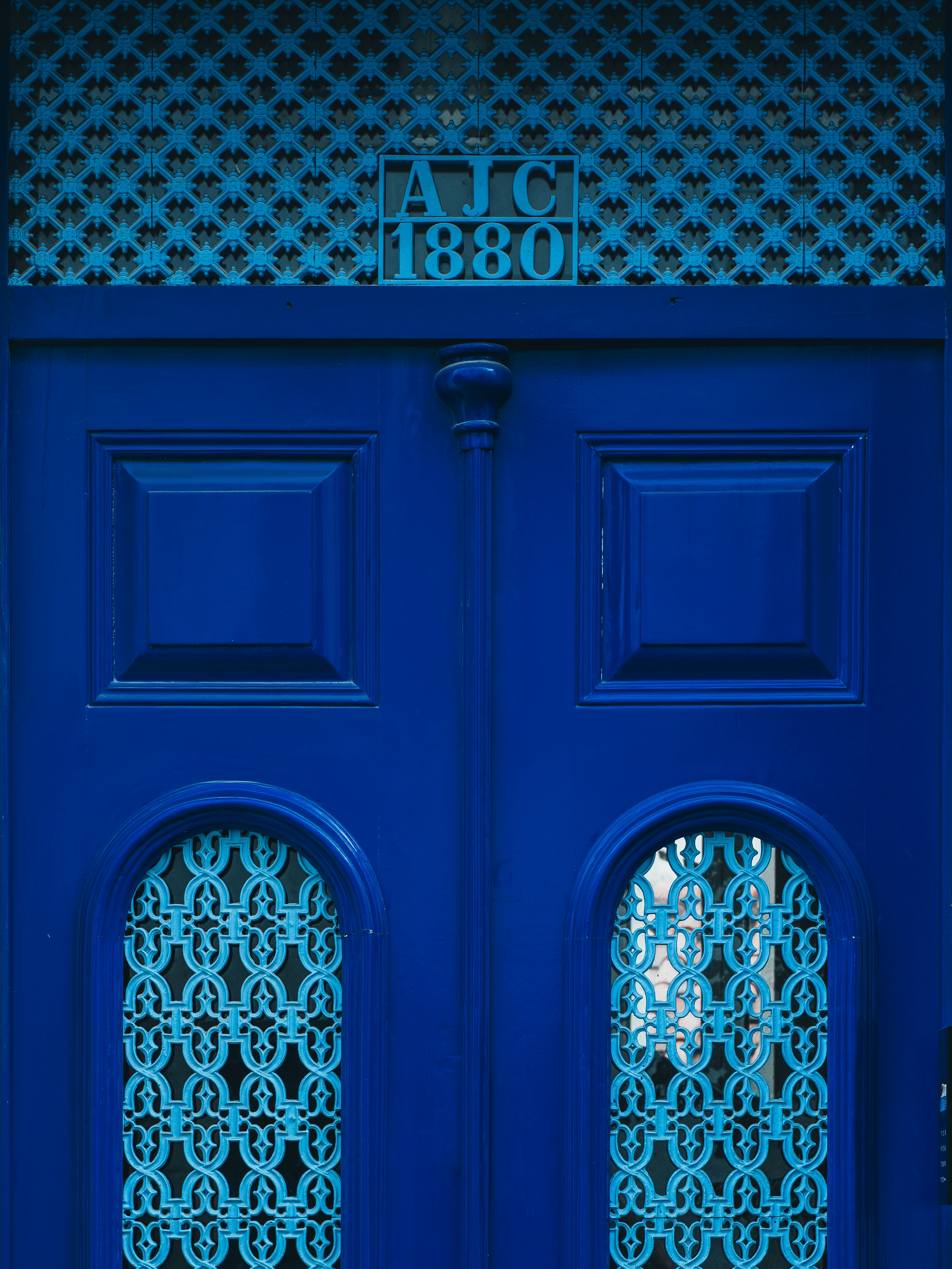A bright blue door with decorative metal accents
