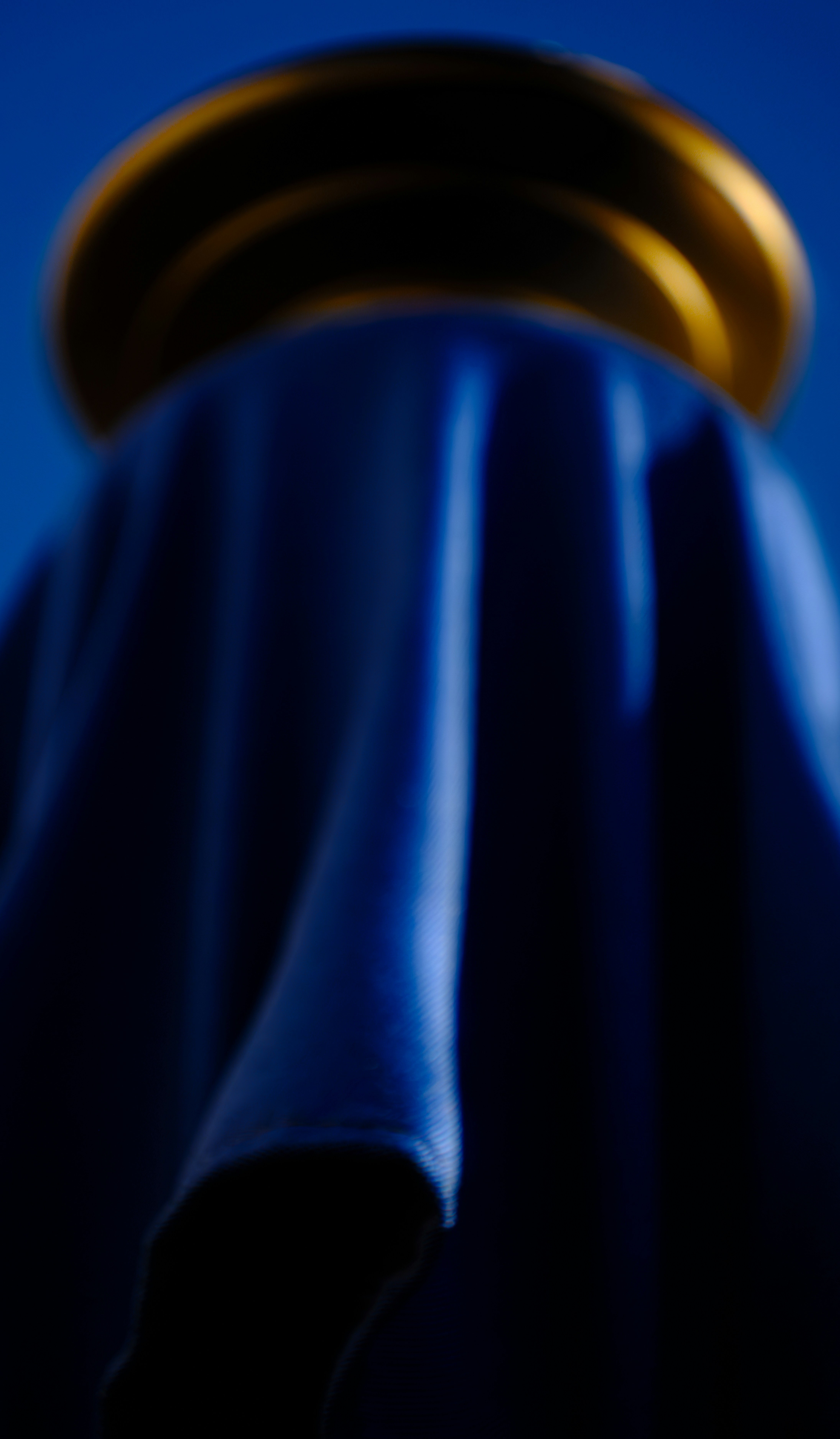 Top of outdoor umbrella | Blue fabric draped over a golden object