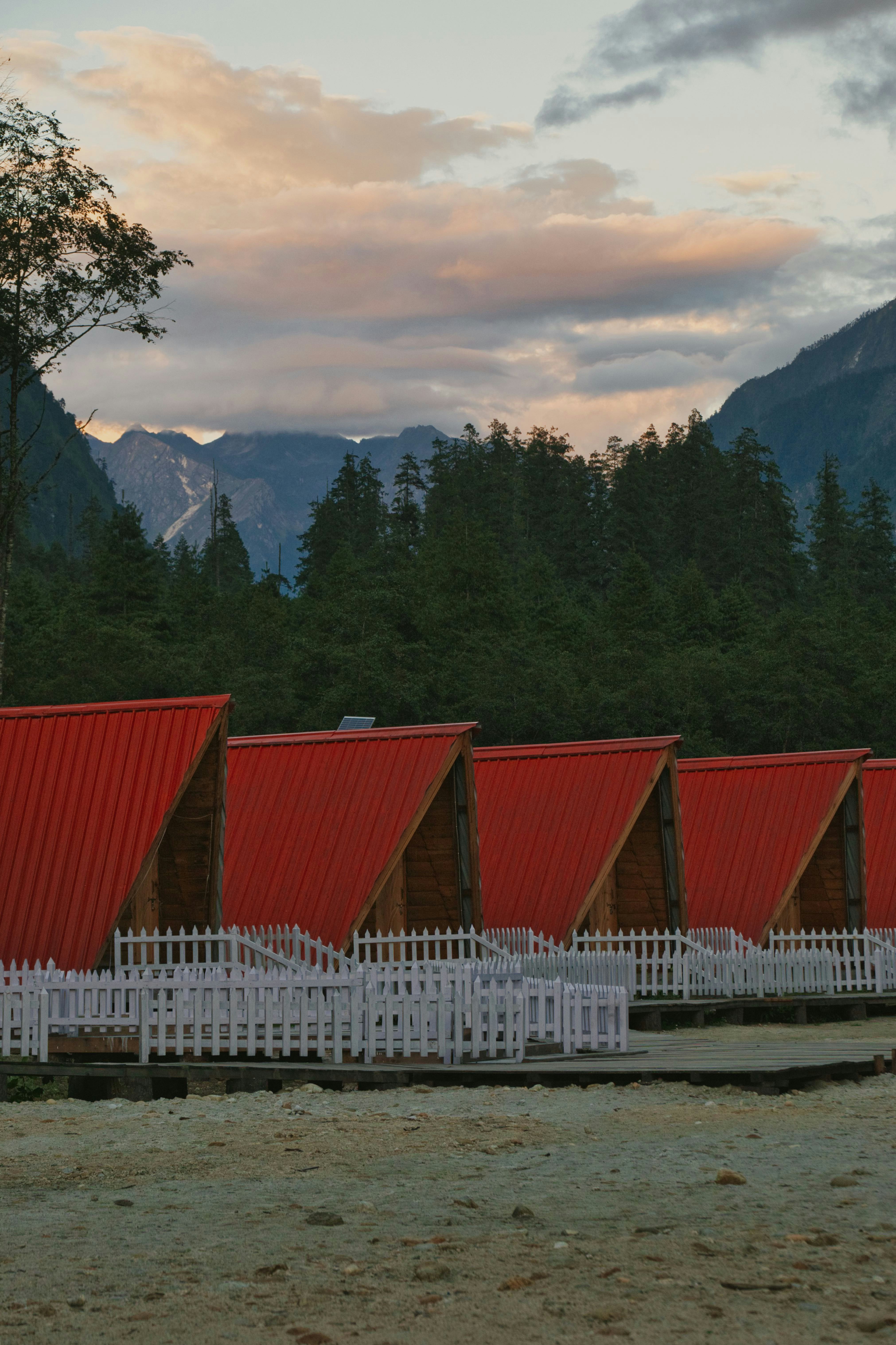 Row of red-roofed cabins with white fences photo – Free Forest Image on ...