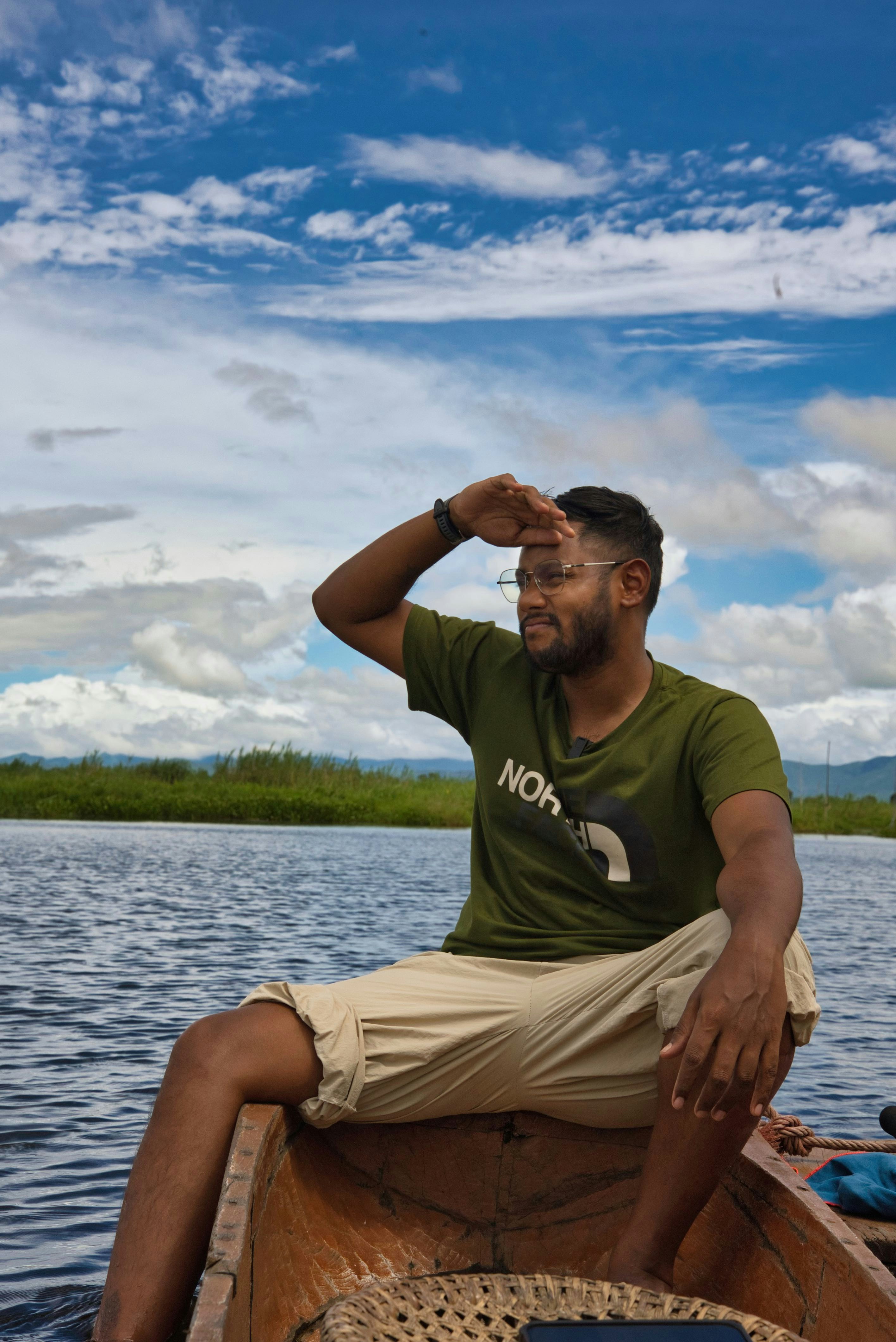Man in boat shields eyes from sun