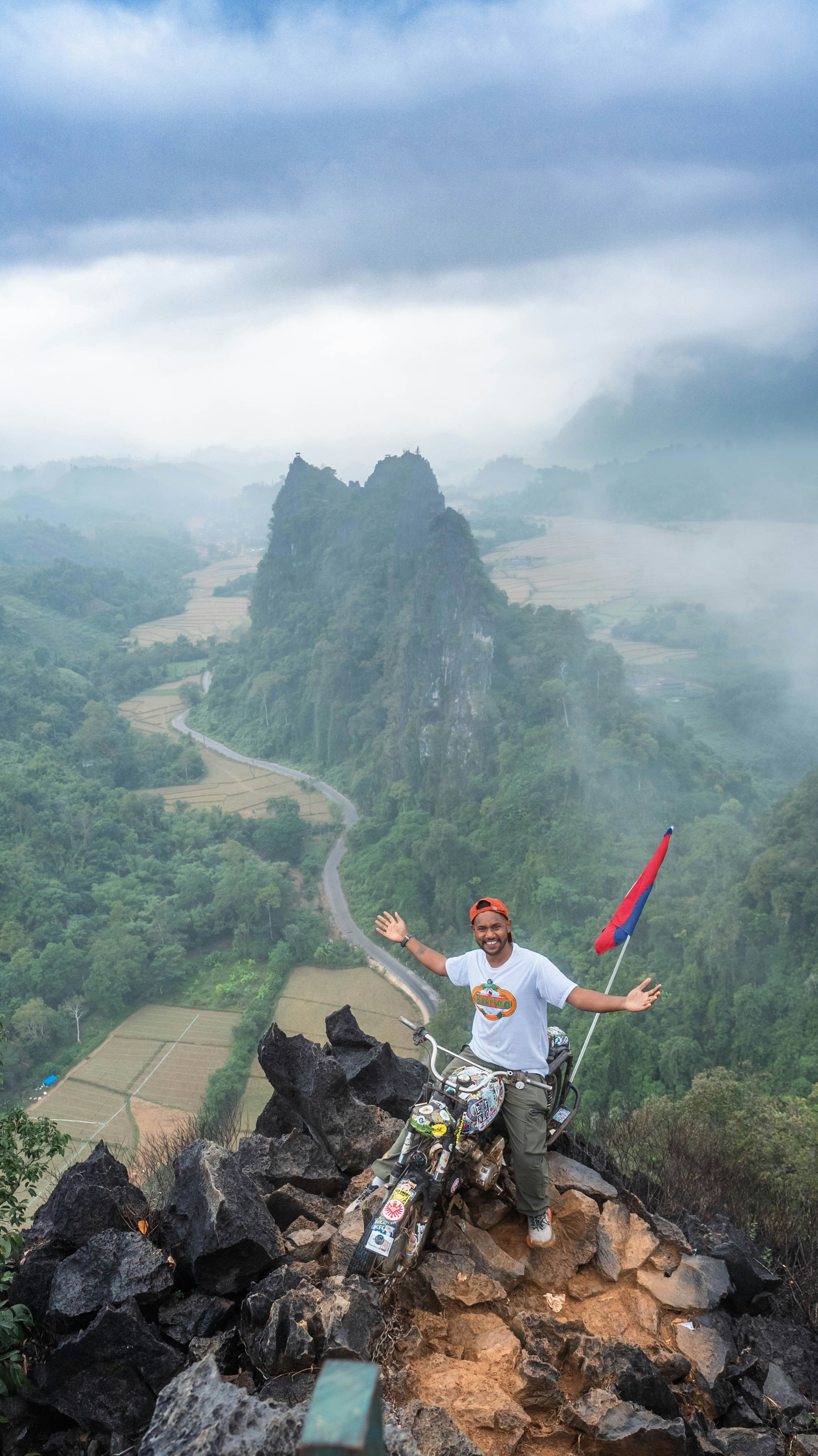 Sky-High Triumph: Rider on the Ridge under Misty Peaks