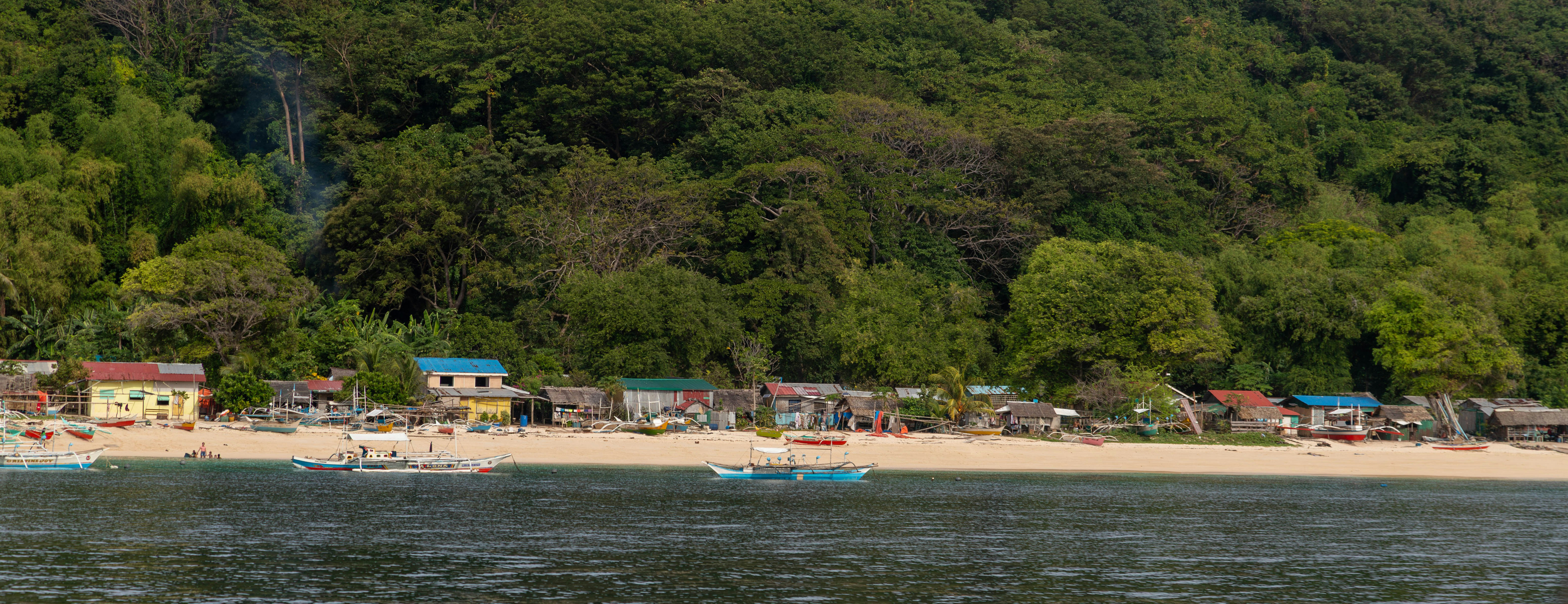 Rainbow Row by the Shore: A Coastal Village Fringing a Calm Sea
